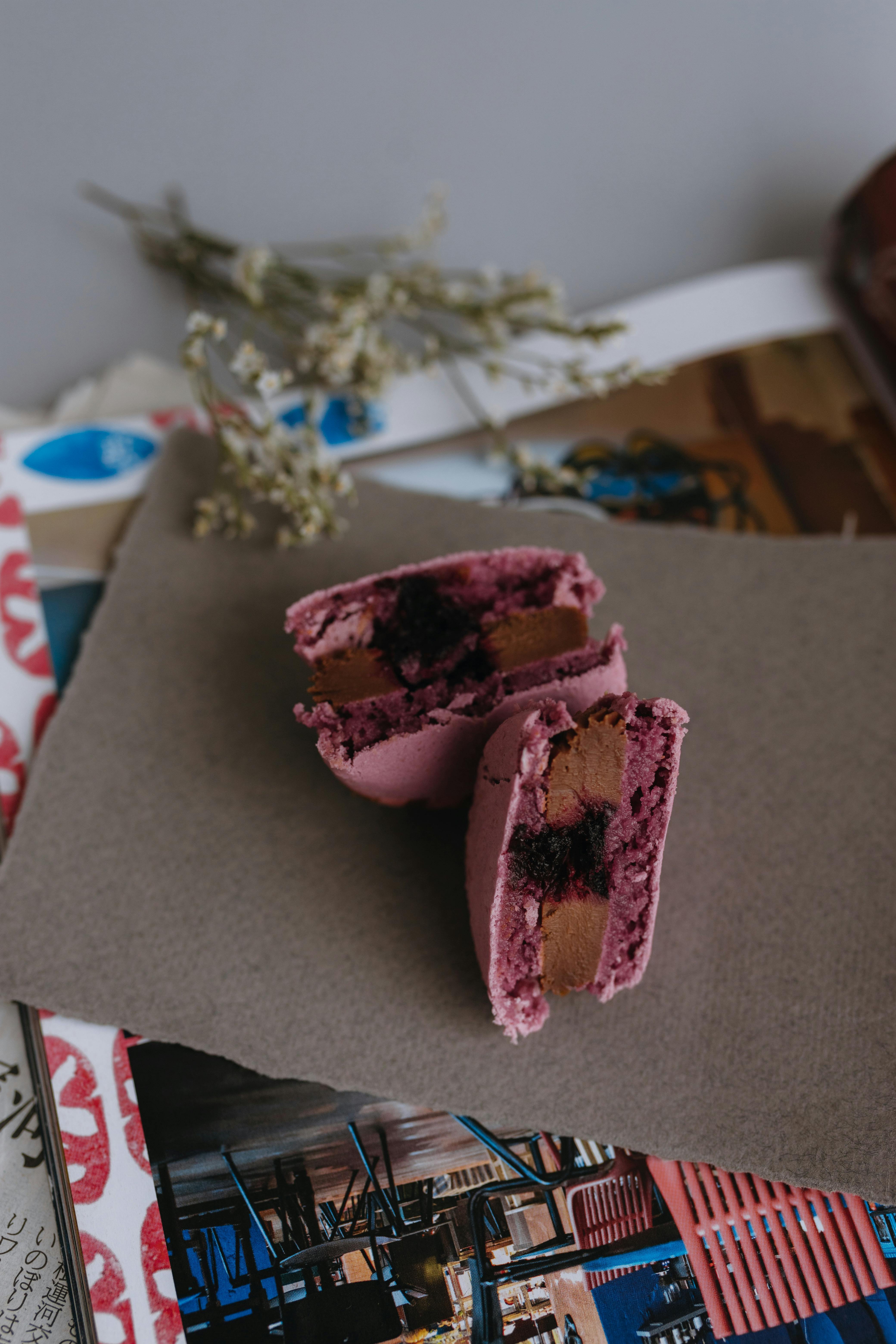 A pink and blue pastry sitting on top of a magazine · Free Stock Photo