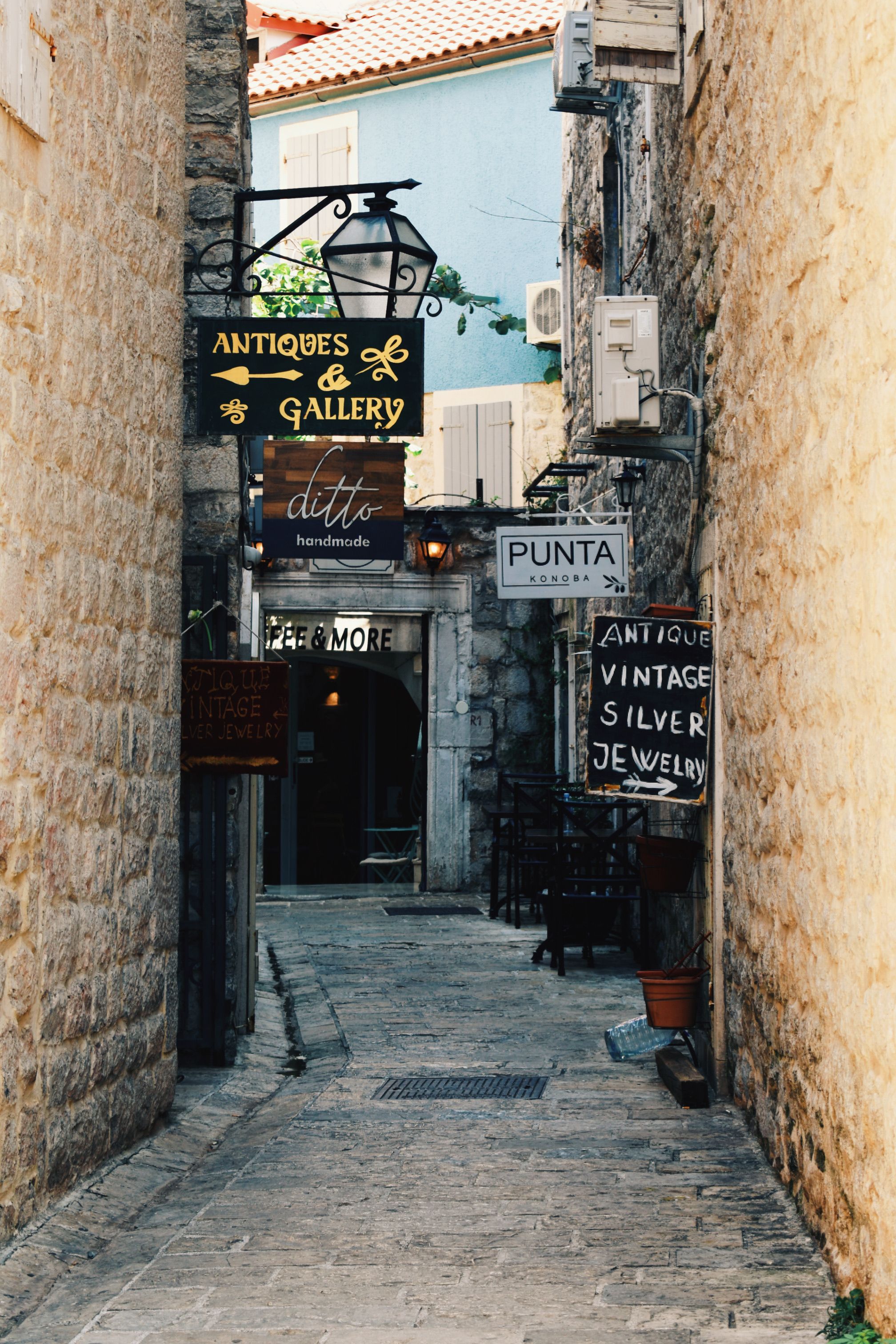 A narrow alley with signs on the walls · Free Stock Photo