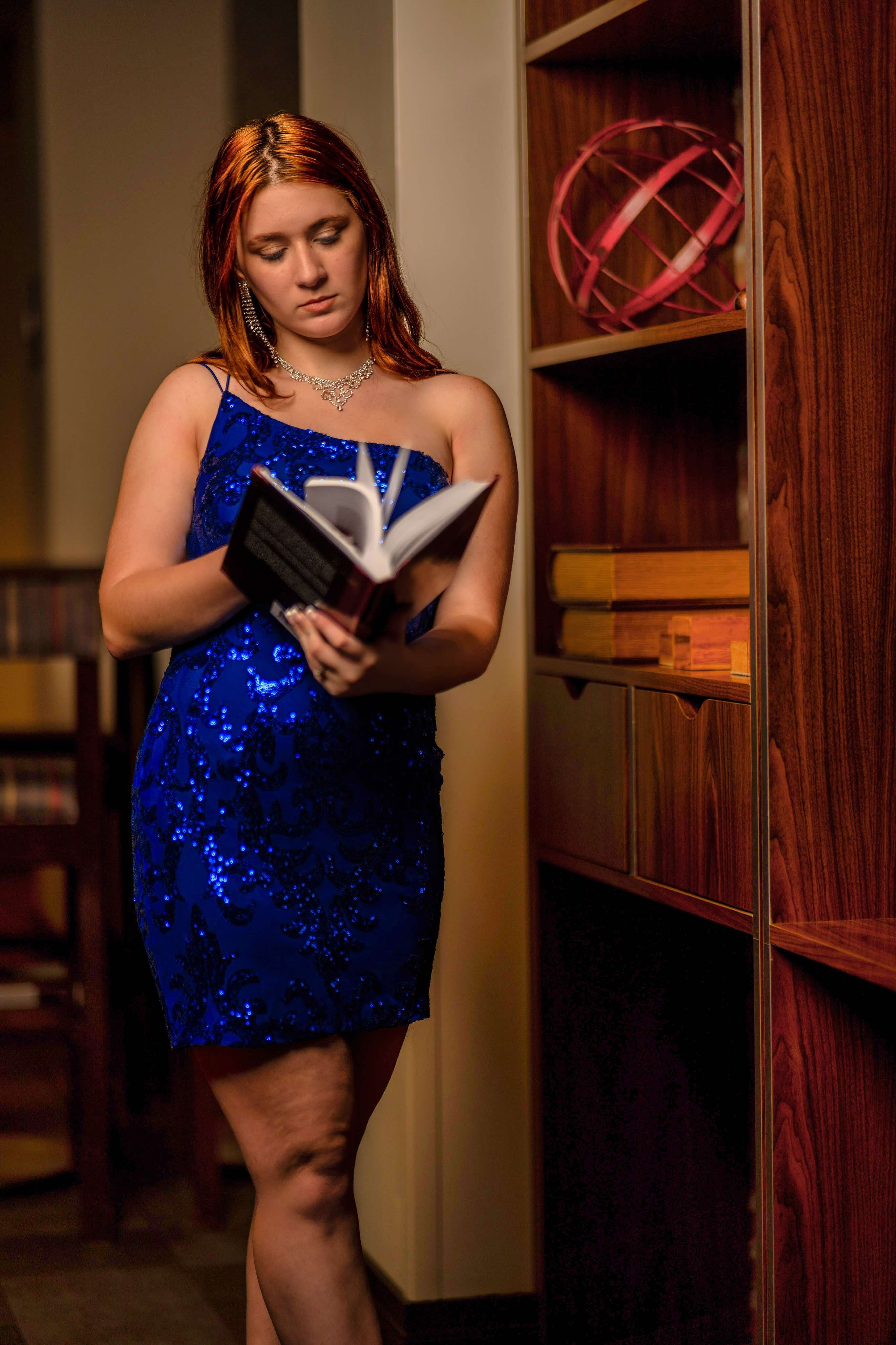 Elegant Woman in Blue Dress Reading in Library · Free Stock Photo
