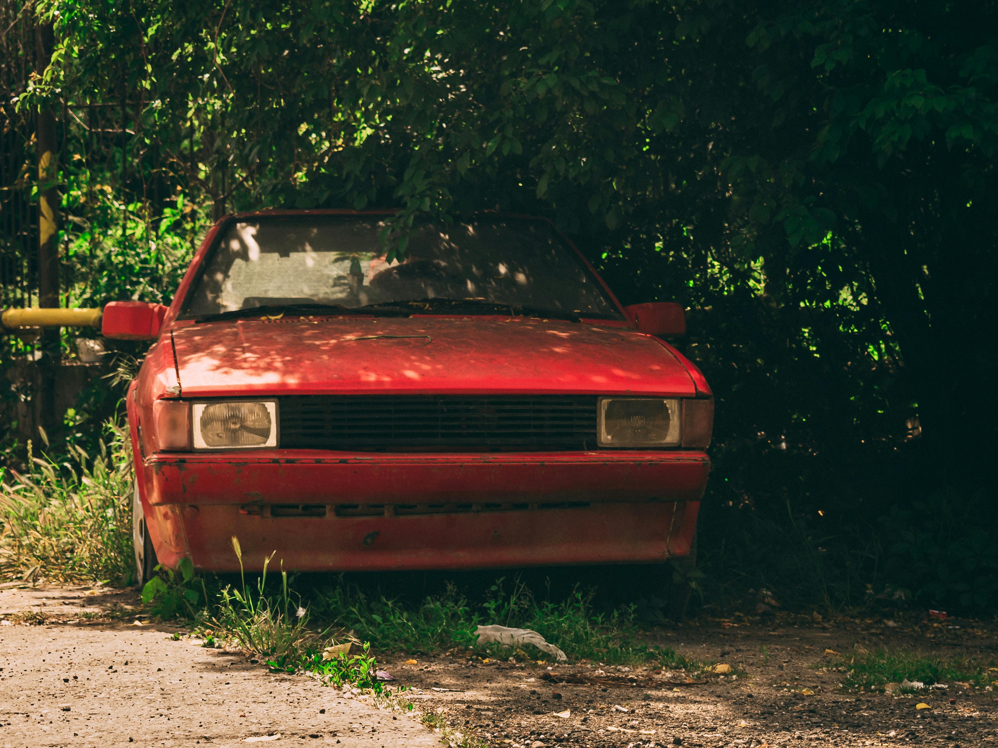 A red car parked in the middle of a field · Free Stock Photo