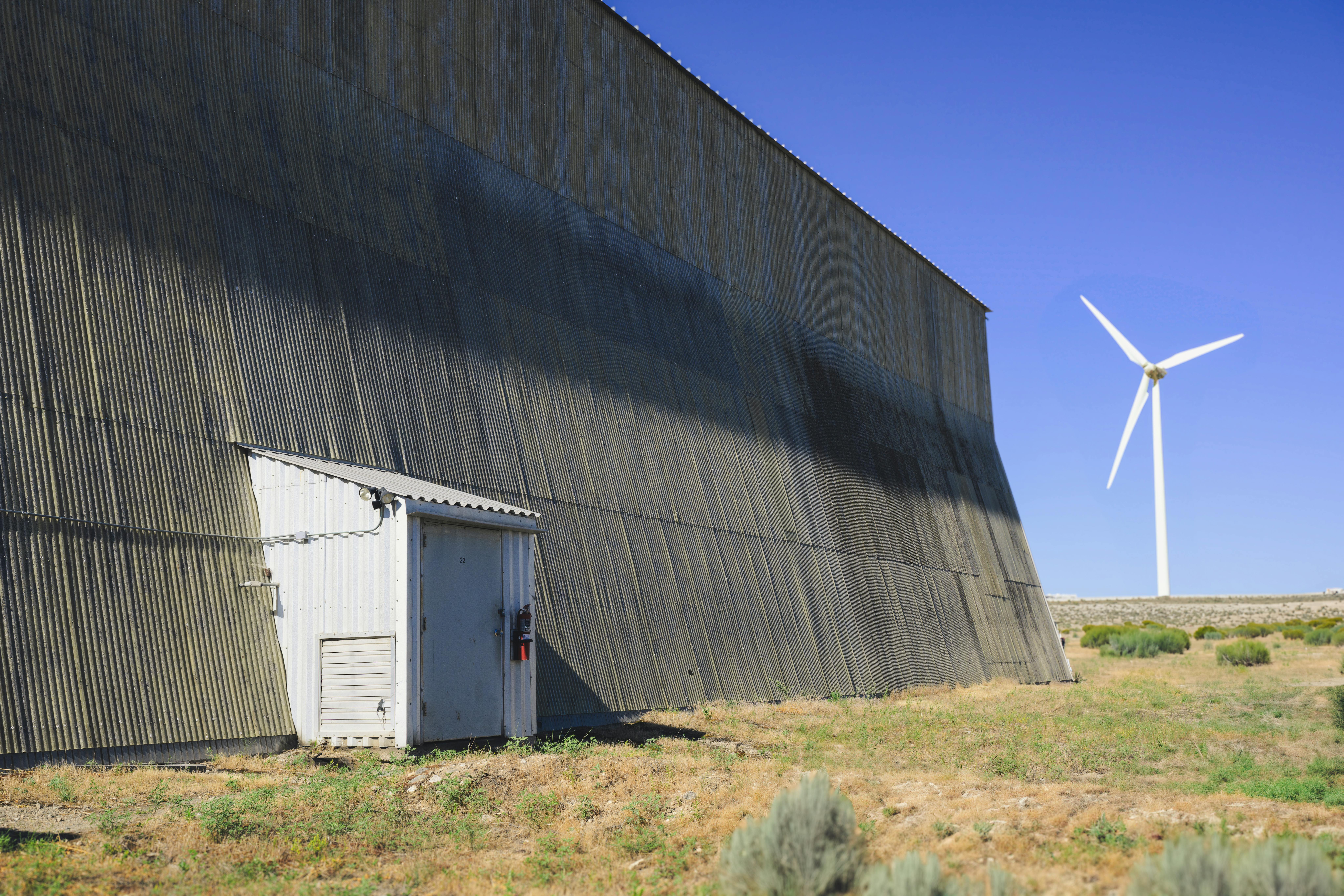 A wind turbine is sitting next to a wall · Free Stock Photo