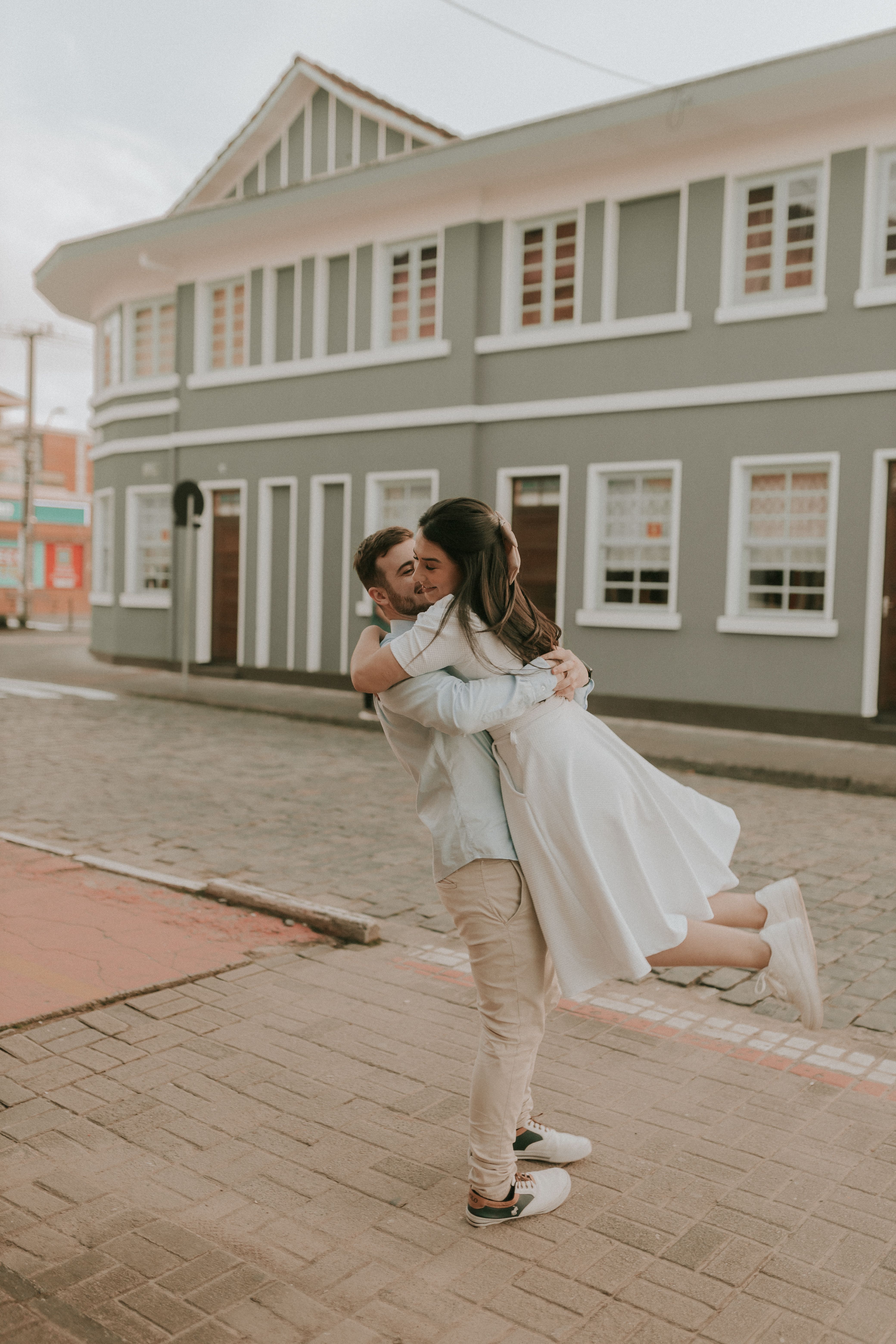 A couple hugging in front of a building · Free Stock Photo