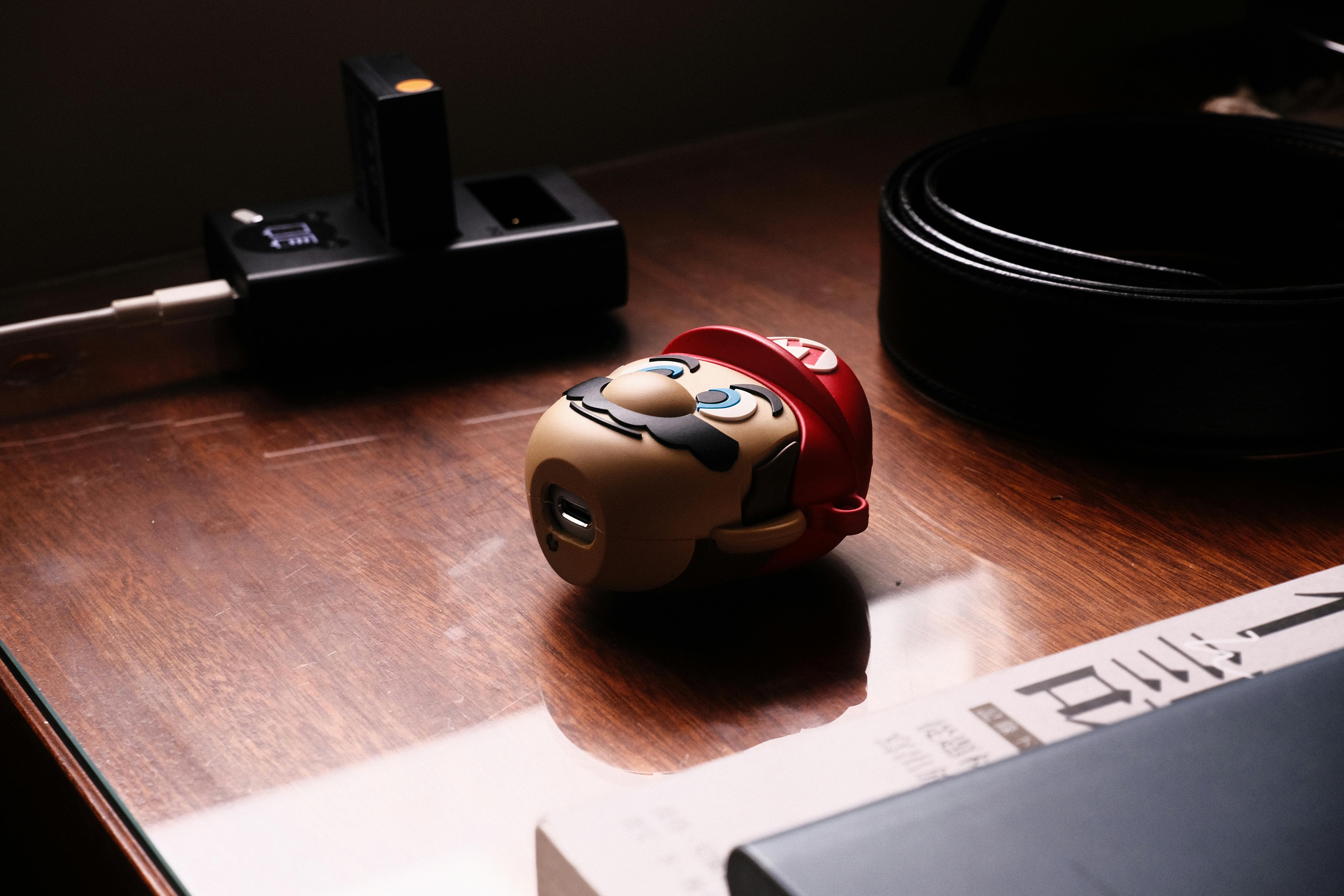 A toy iron man sitting on a desk next to a computer · Free Stock Photo