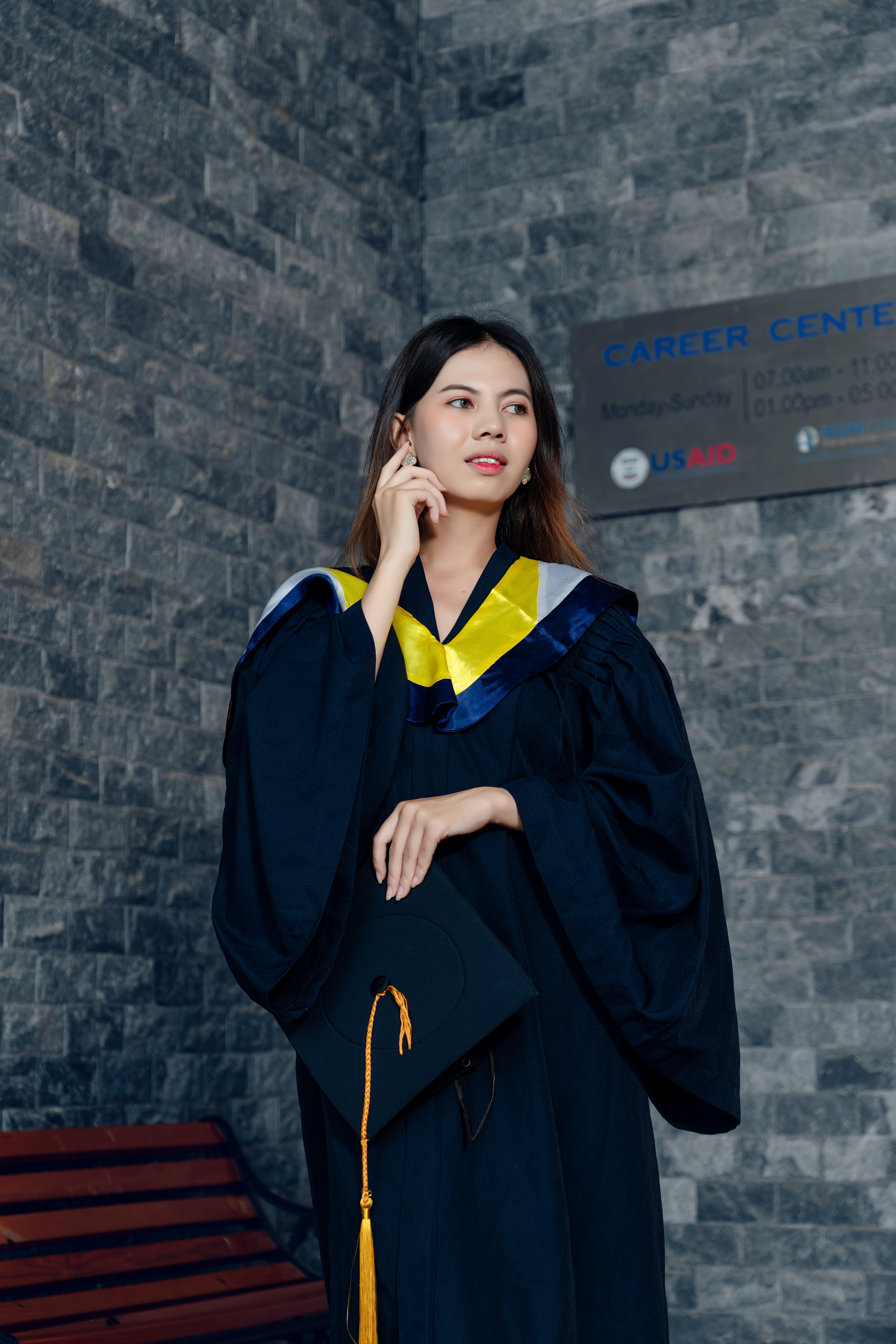 A woman in a graduation gown is talking on her phone · Free Stock Photo