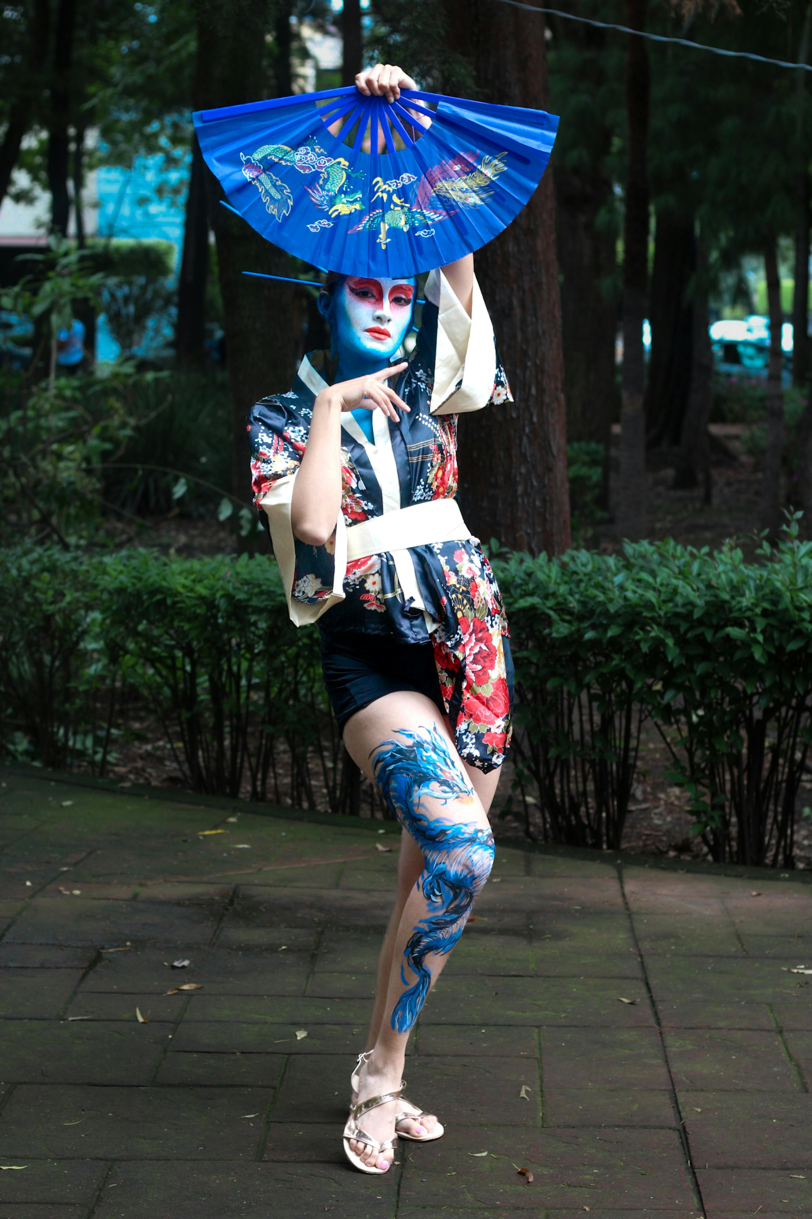 A woman in a geisha costume with a blue umbrella · Free Stock Photo