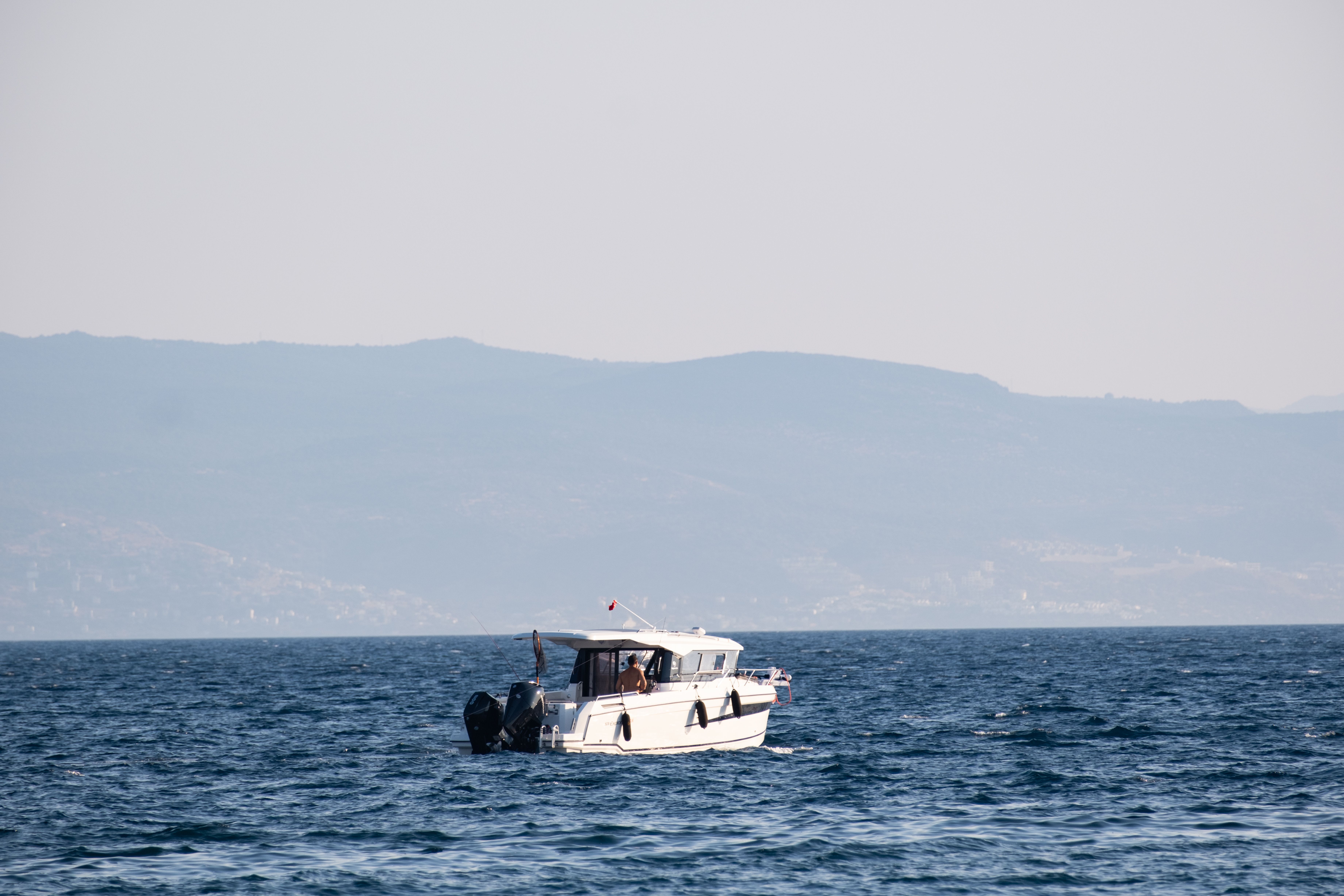 A small boat is traveling through the ocean · Free Stock Photo