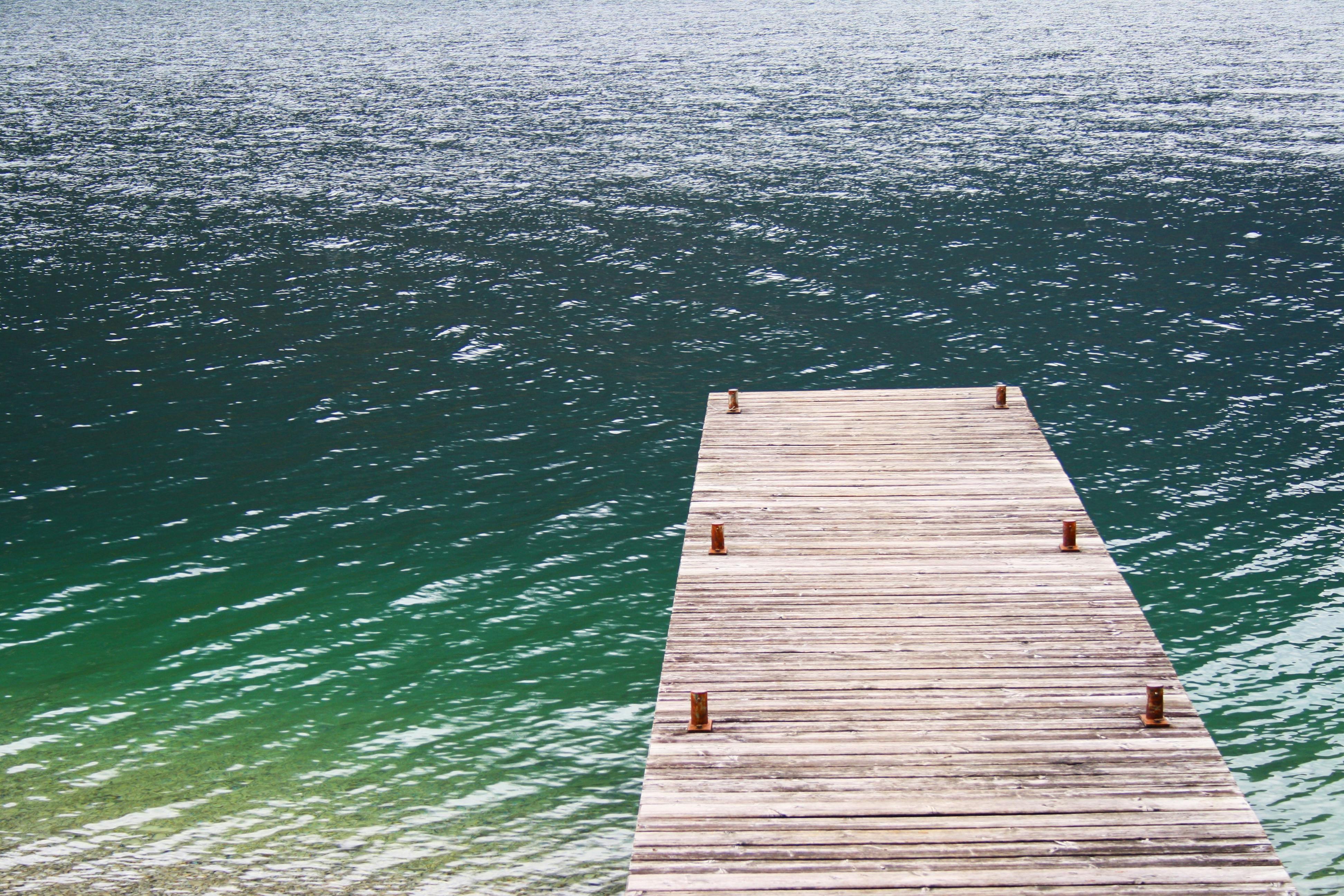 Wooden pier corner above calm rippling lake · Free Stock Photo