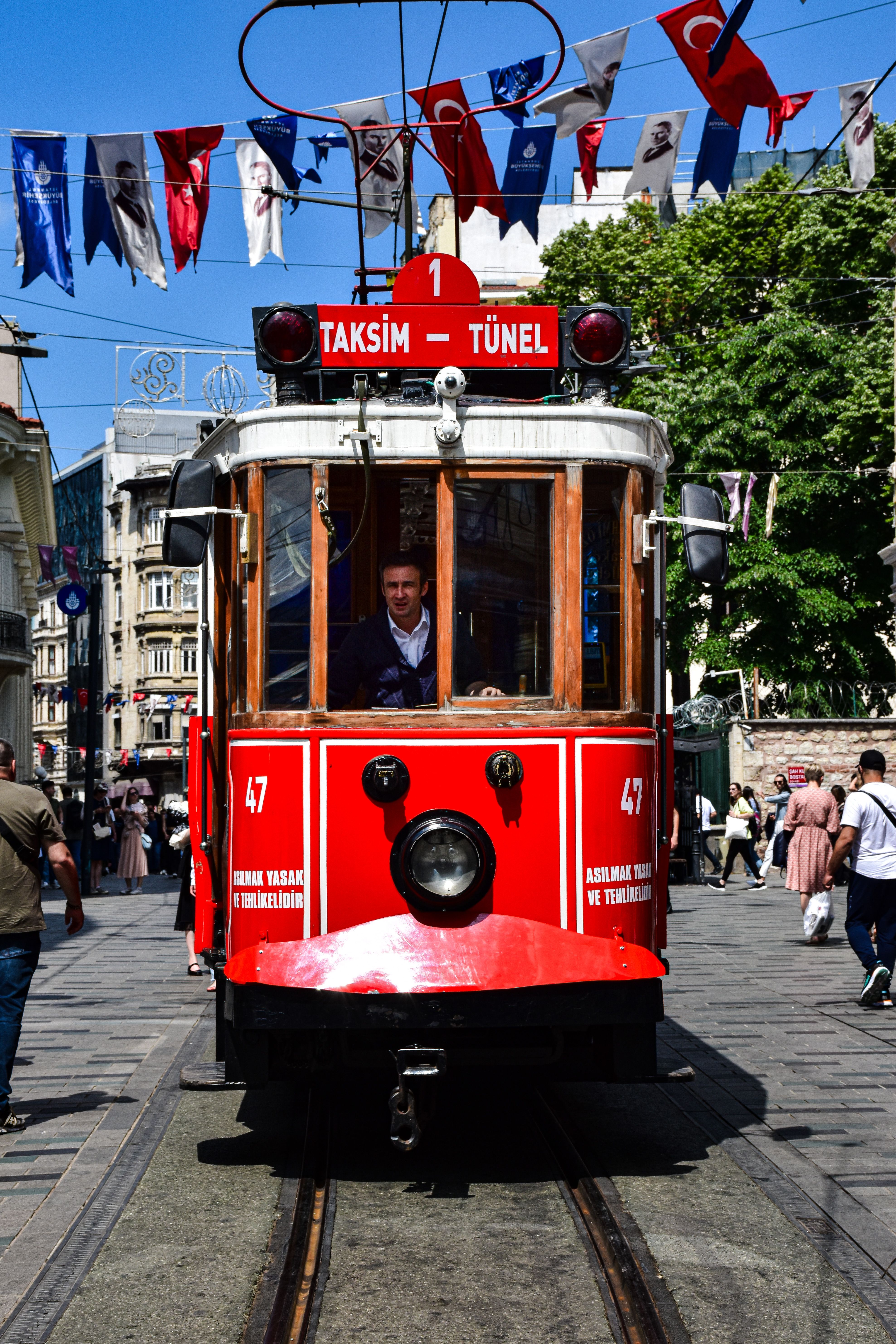 A red trolley car is traveling down a street · Free Stock Photo