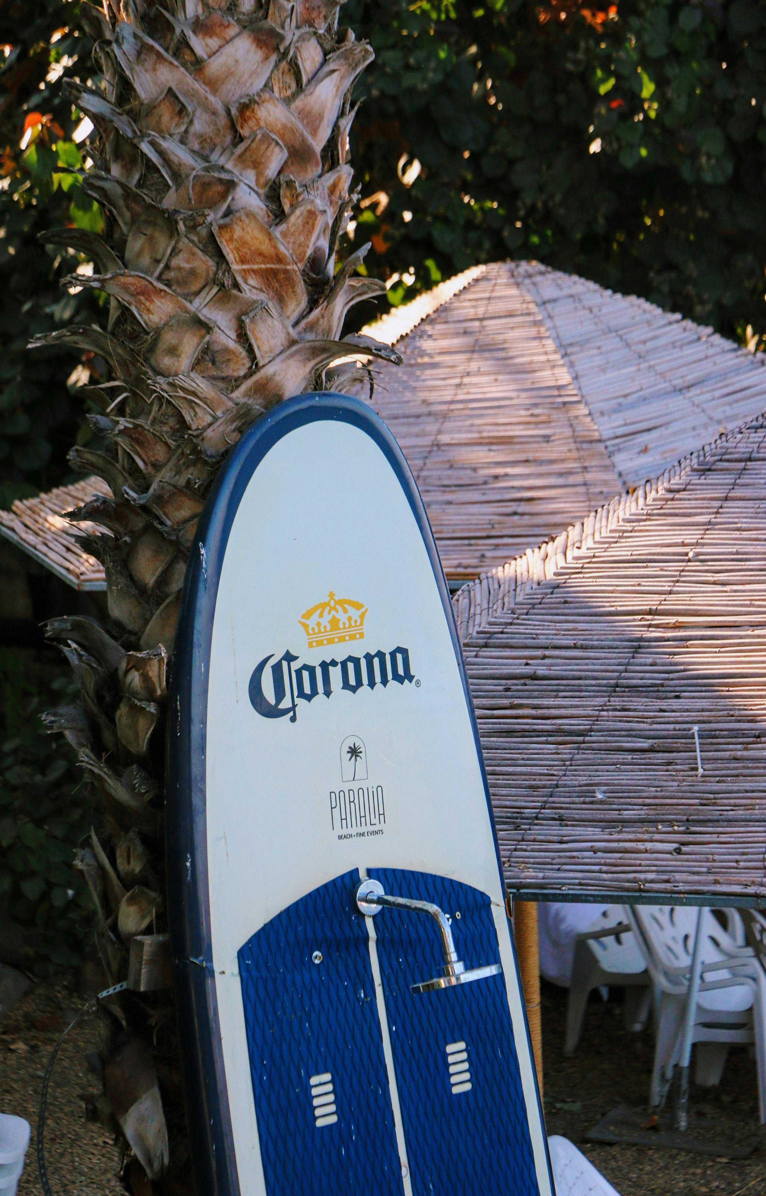 A surfboard with a corona beer logo on it · Free Stock Photo