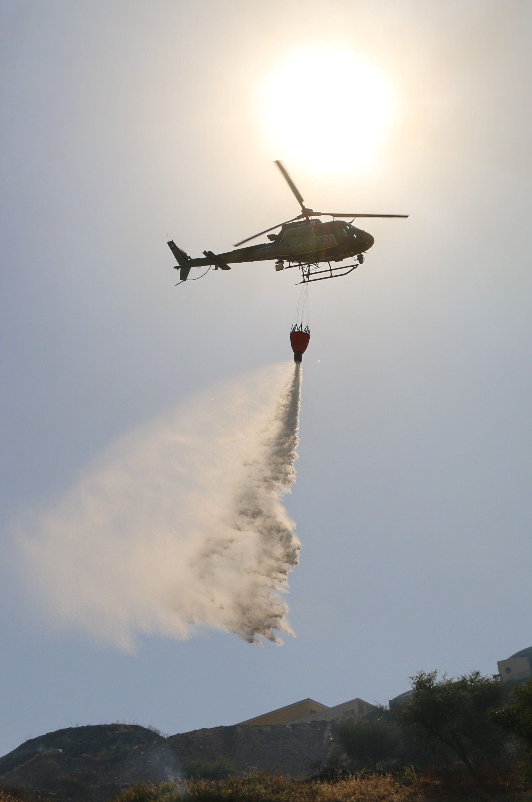 A helicopter spraying water from a fire hose · Free Stock Photo