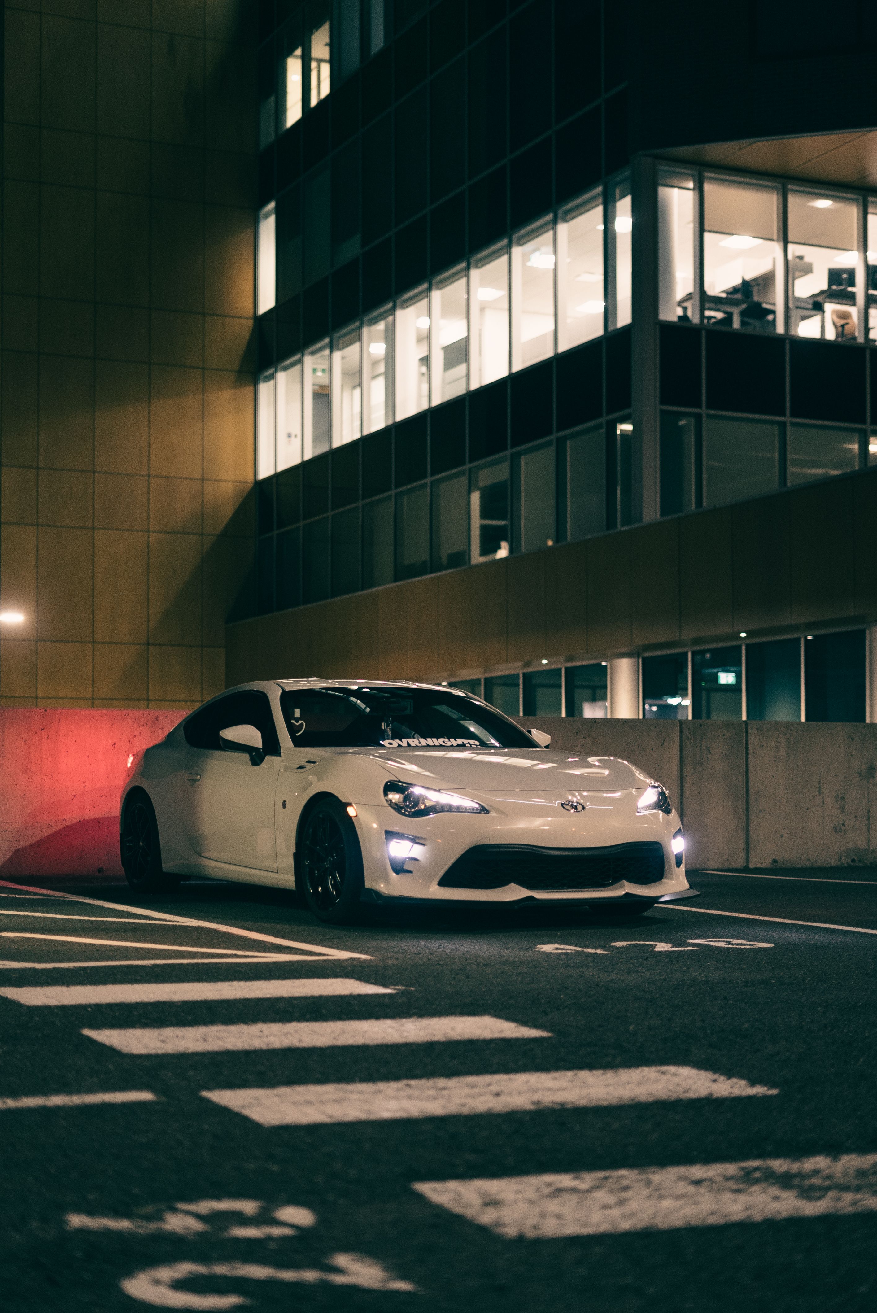 A white car parked in front of a building · Free Stock Photo