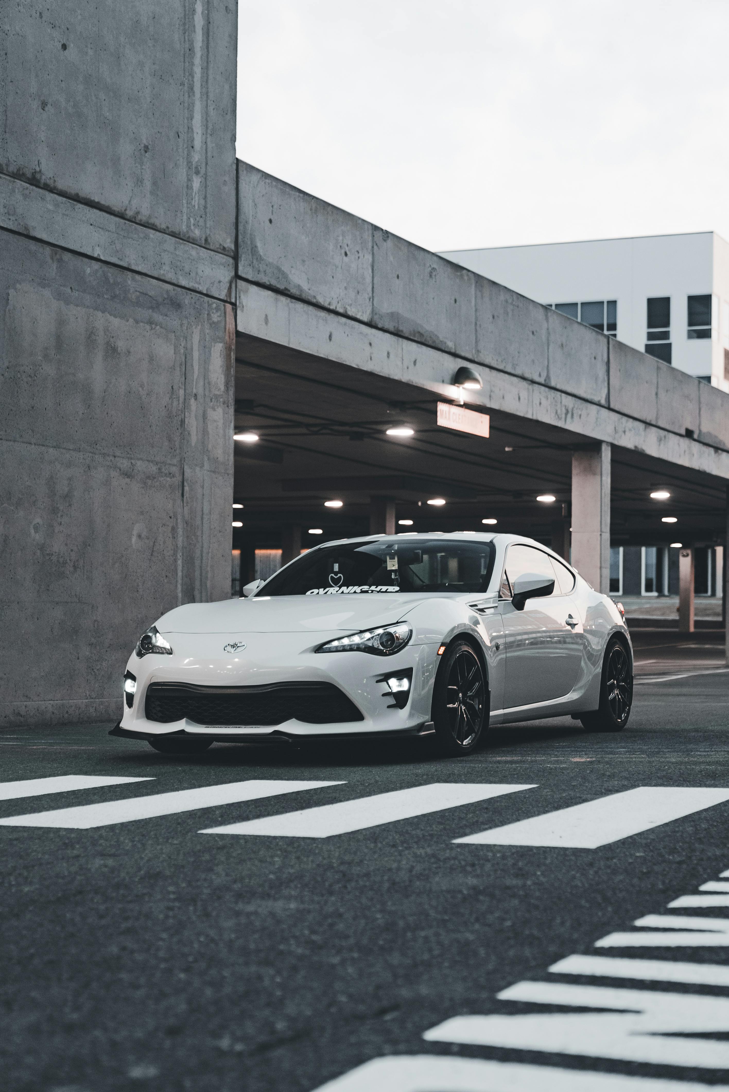 Un Coche Deportivo Toyota Blanco Esperando Delante De Un Paso De Cebra ...