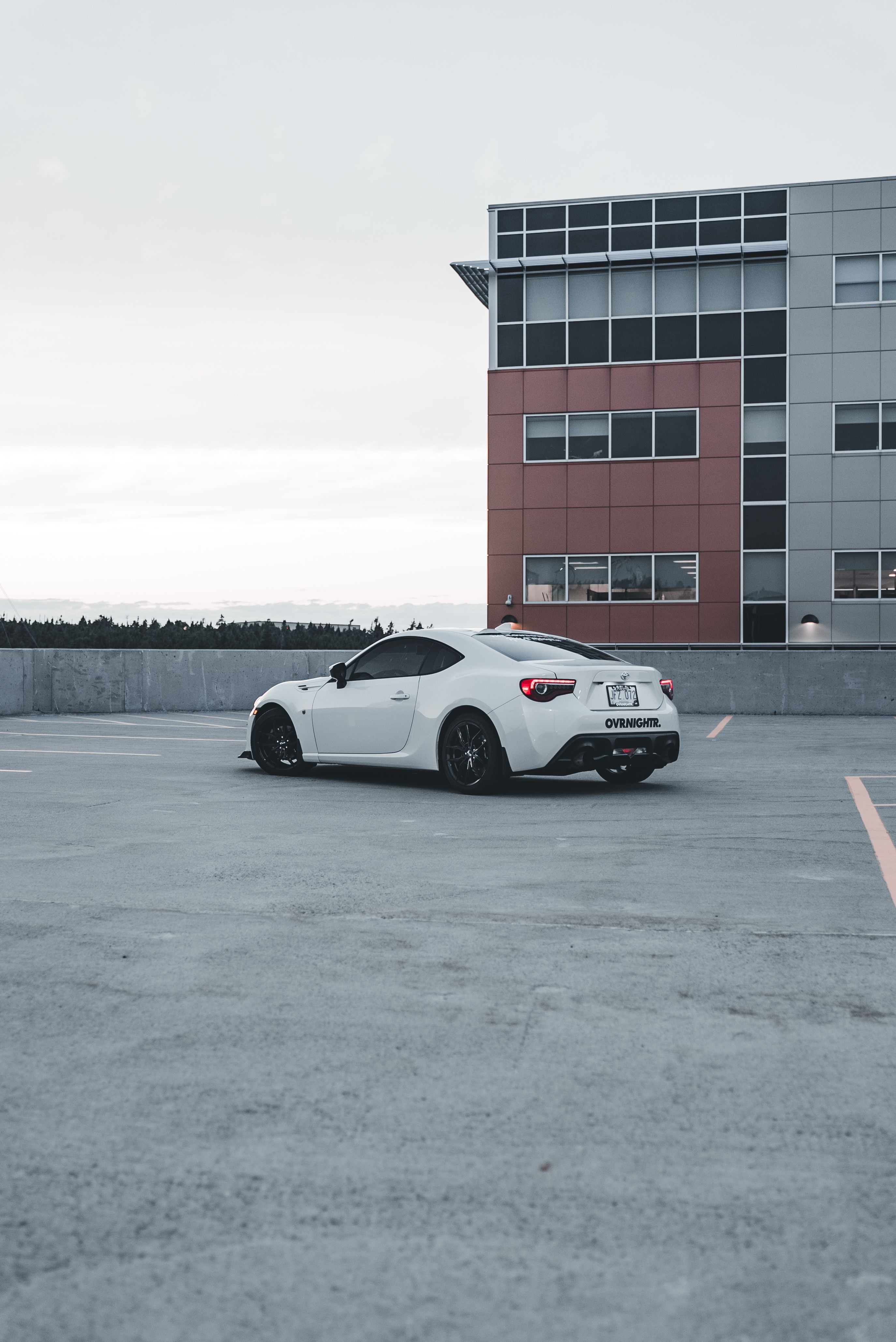 A white sports car parked in front of a building · Free Stock Photo