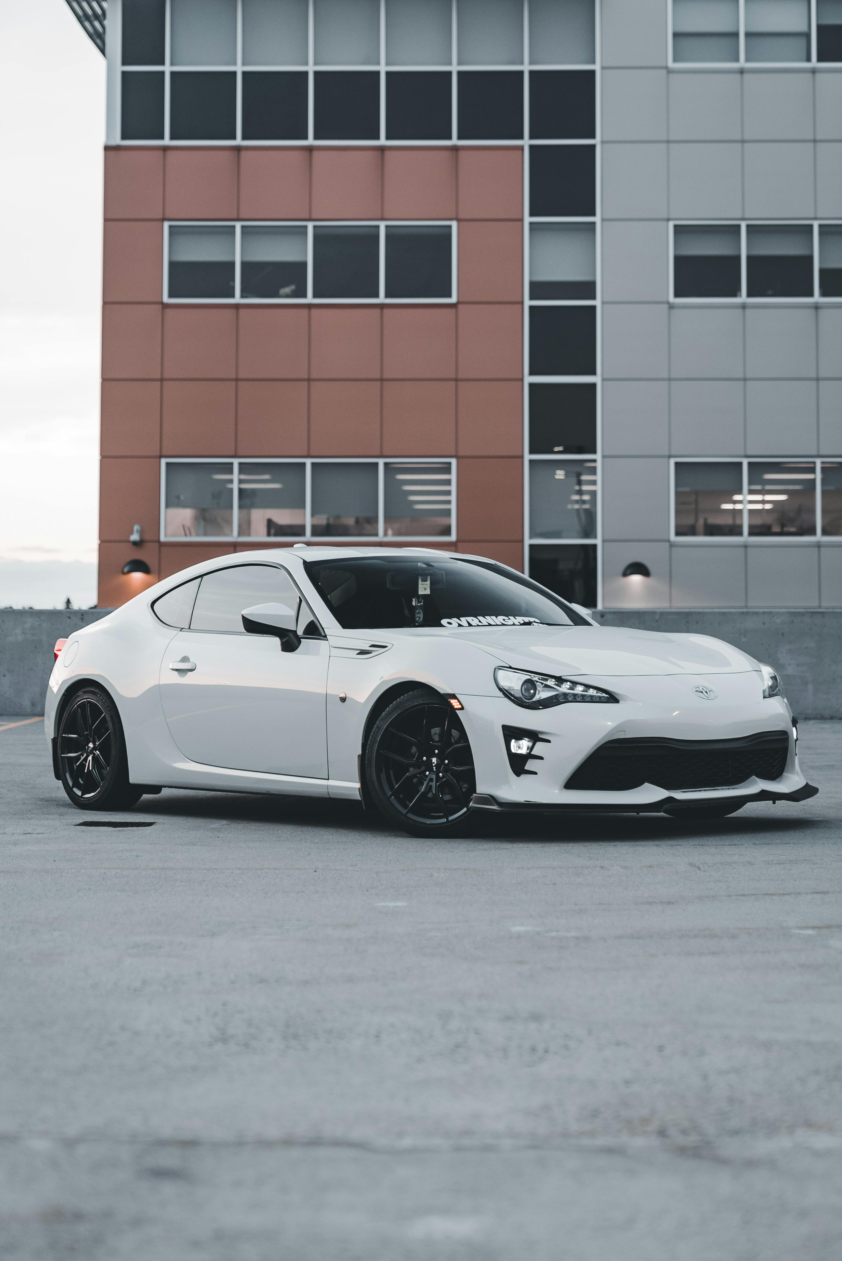 White Toyota Sports Car Parked in a Rooftop Parking Lot · Free Stock Photo