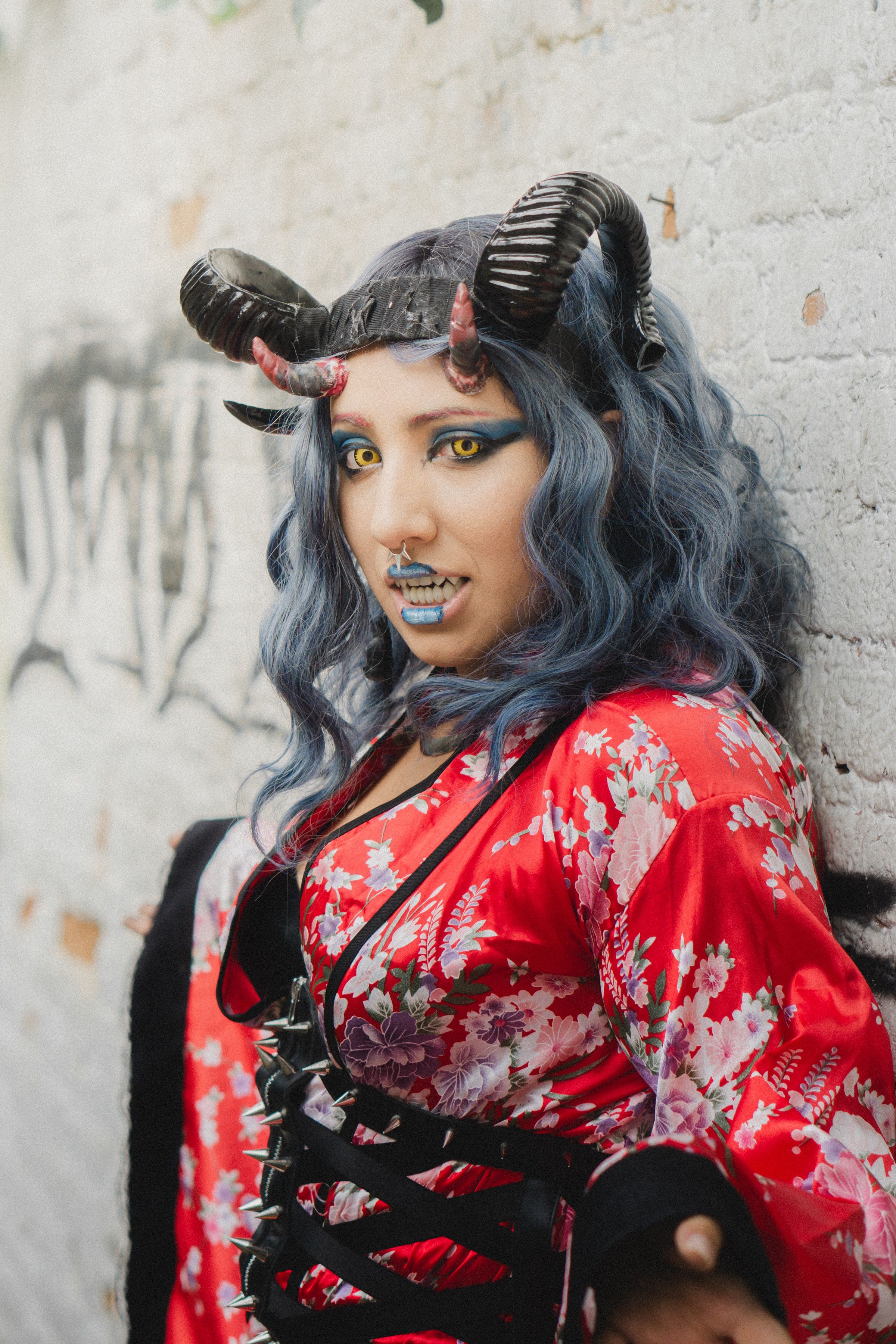 A woman with blue hair and horns is posing · Free Stock Photo