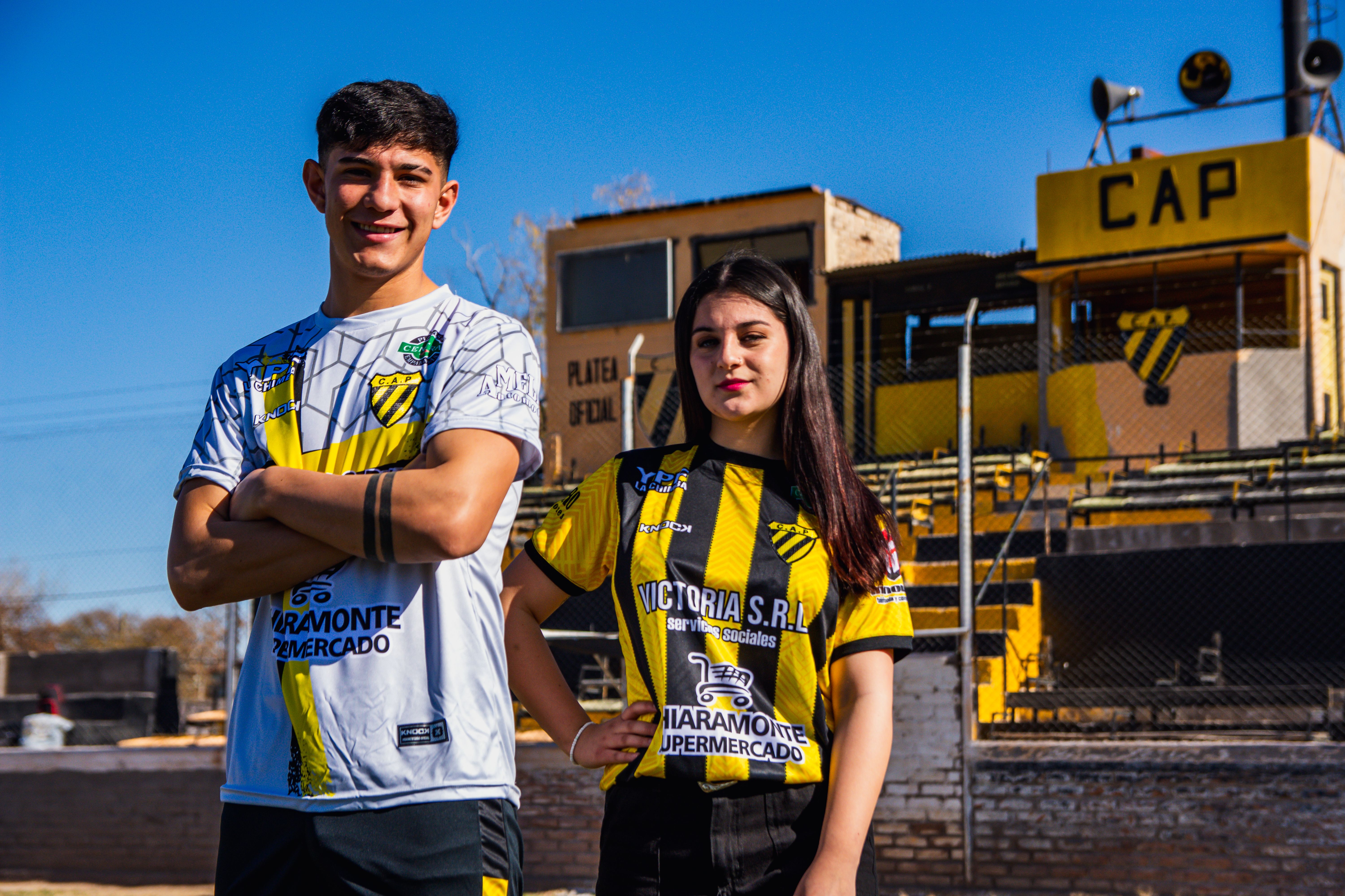 Two people standing next to each other in front of a stadium · Free ...