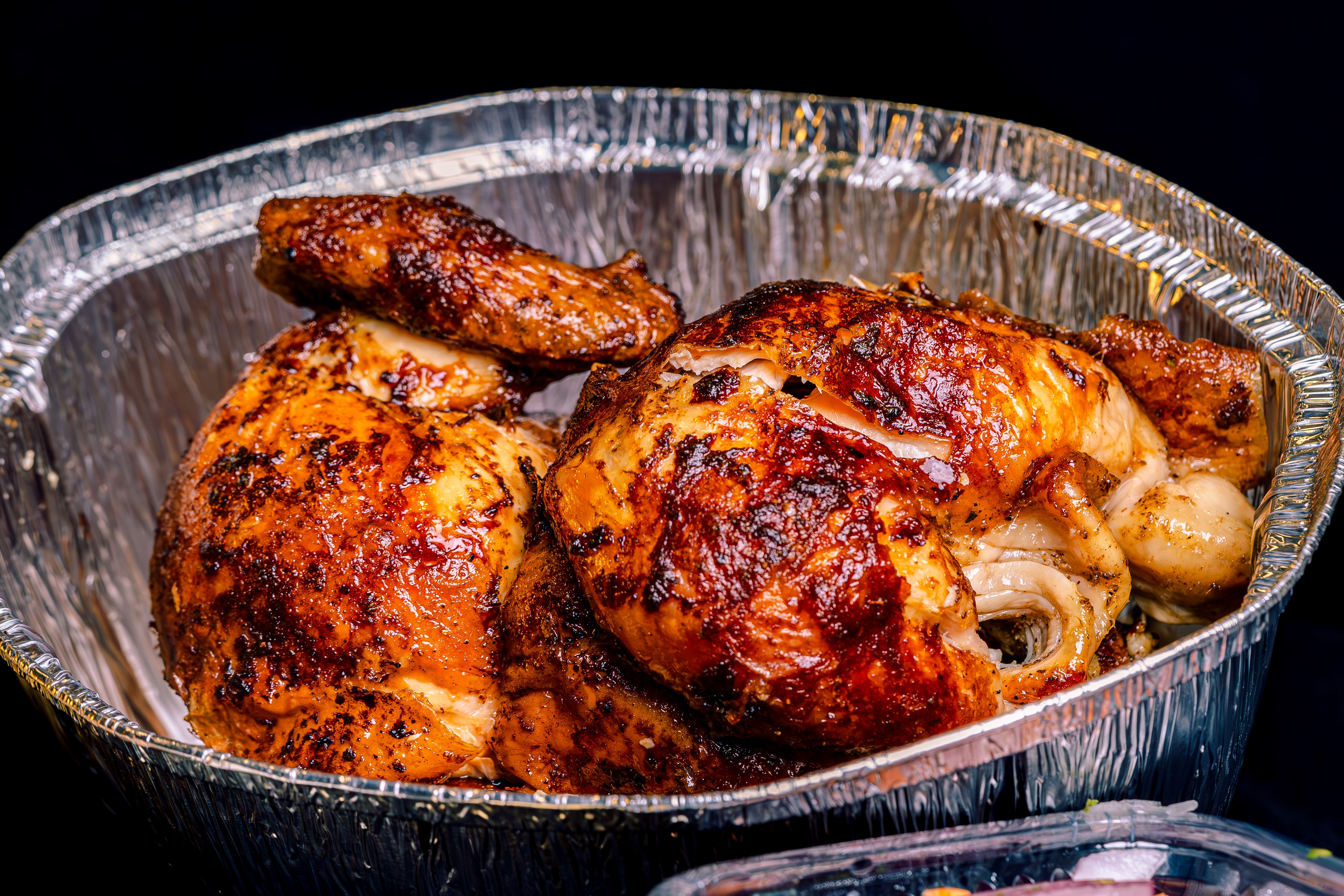 A close up of two chicken legs in a tin foil · Free Stock Photo
