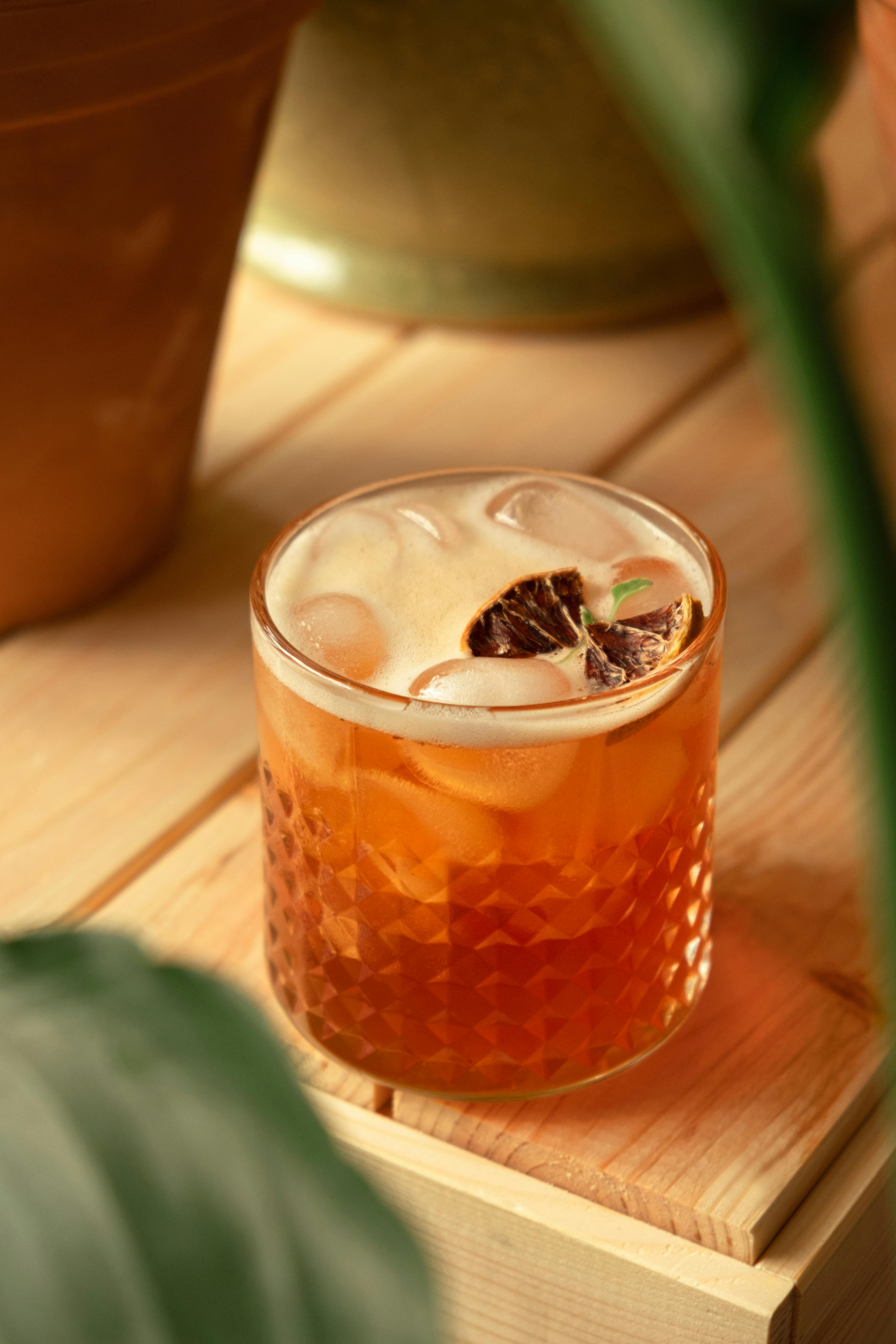 Lowball Glass of Orange Cocktail with Ice Cubes · Free Stock Photo