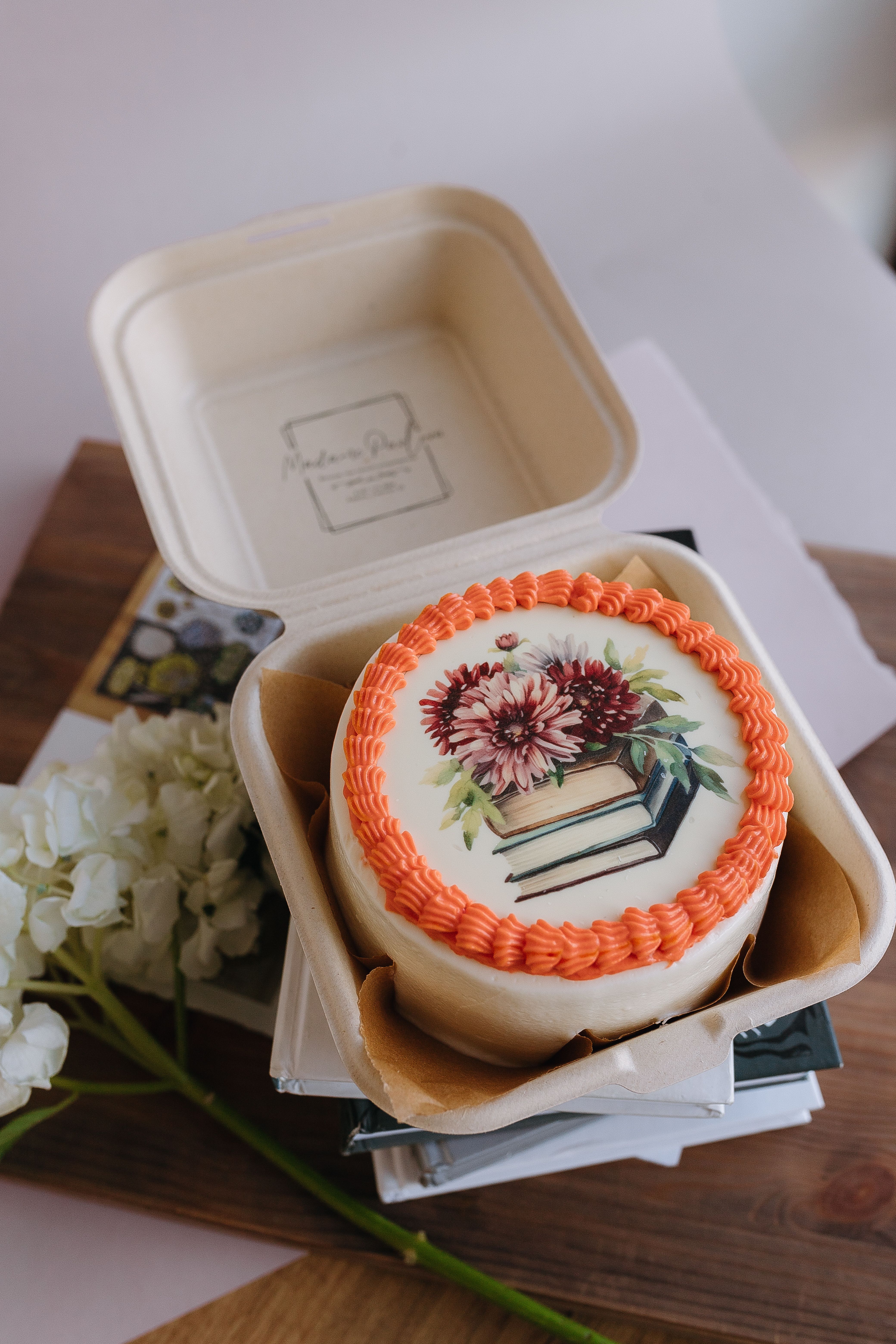 A cake with flowers and a book on top of it · Free Stock Photo