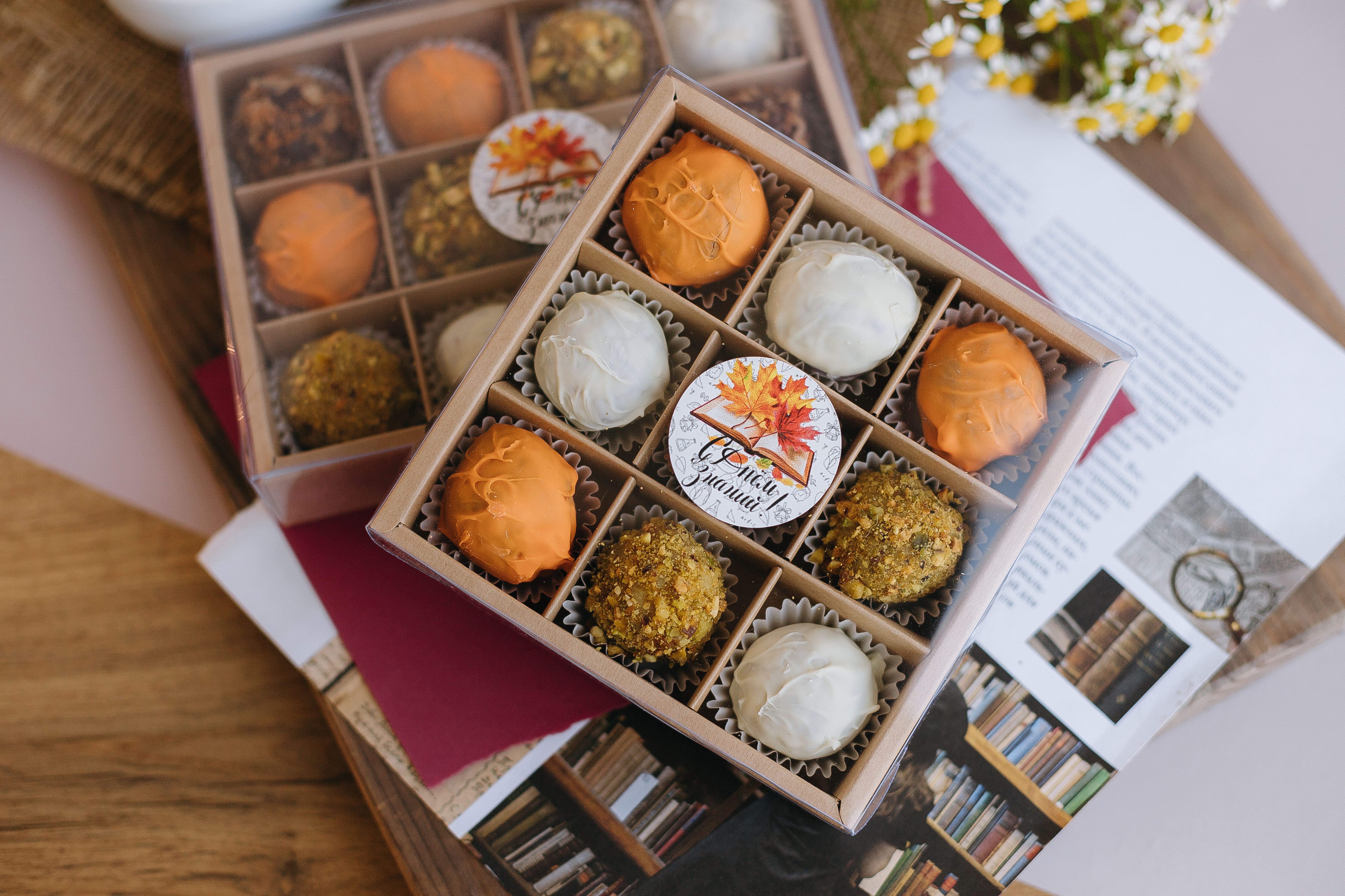 A box of chocolates with different flavors and a book · Free Stock Photo
