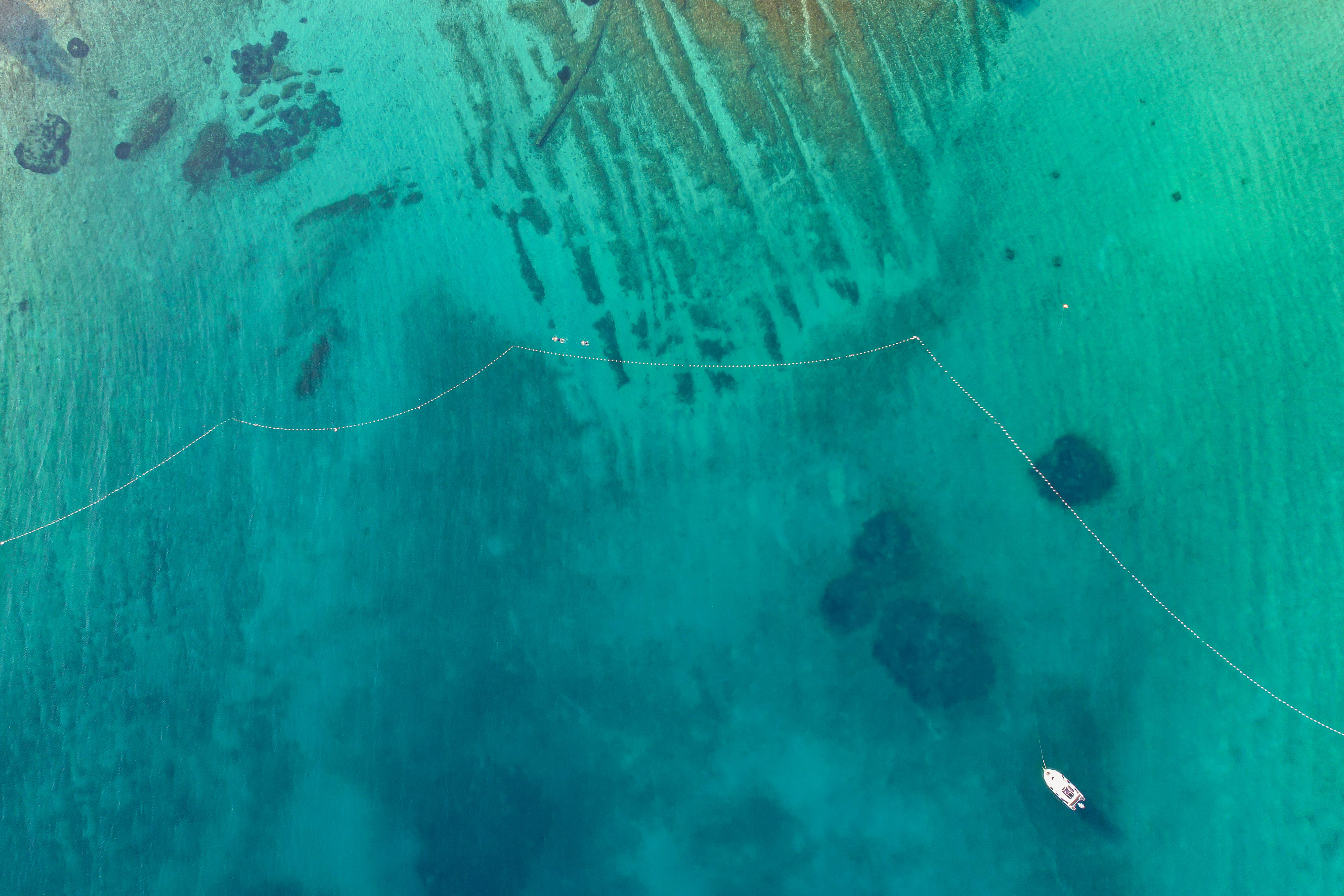 Aerial view of the ocean with a boat in the middle · Free Stock Photo