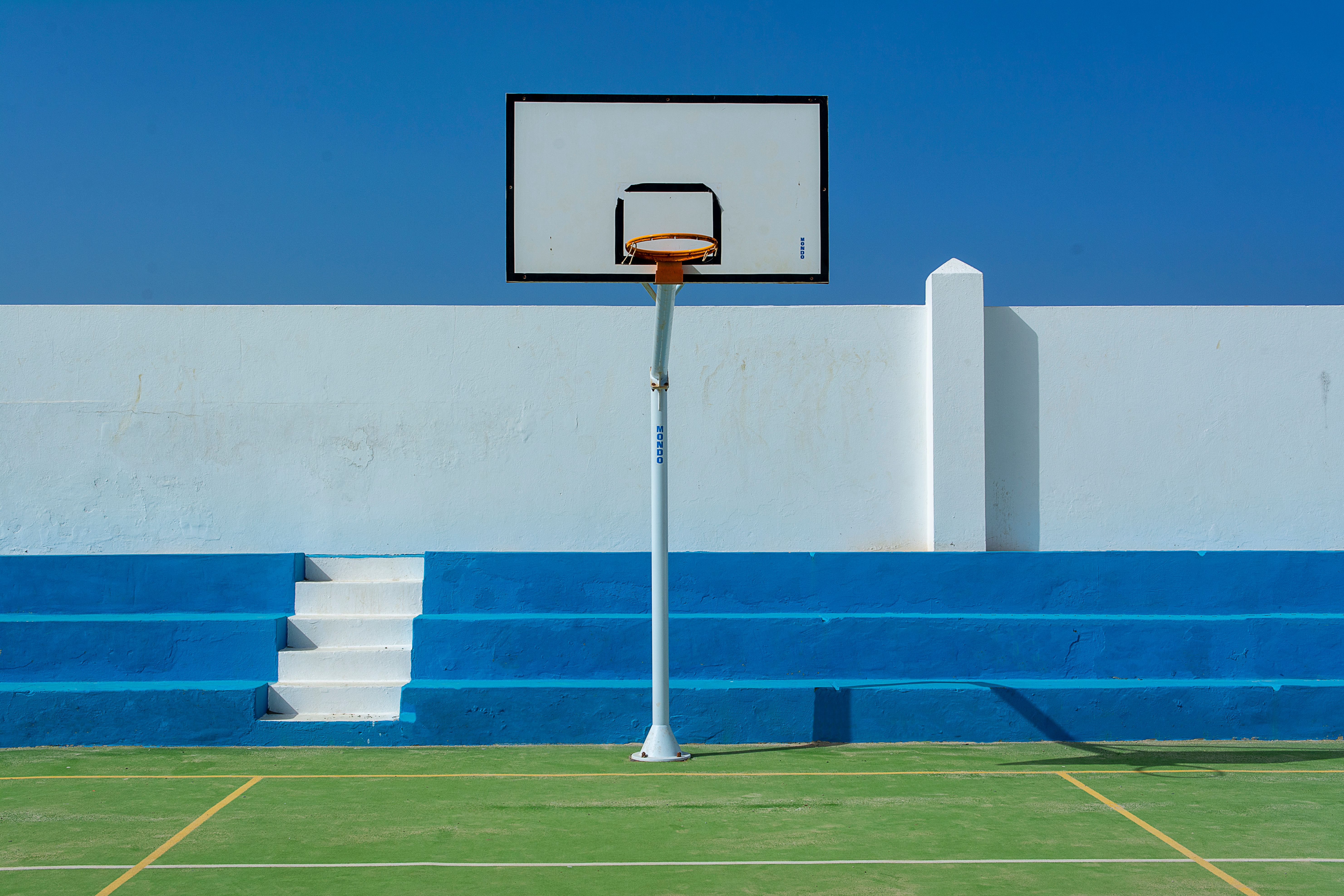 A basketball hoop in a blue and white walled area · Free Stock Photo