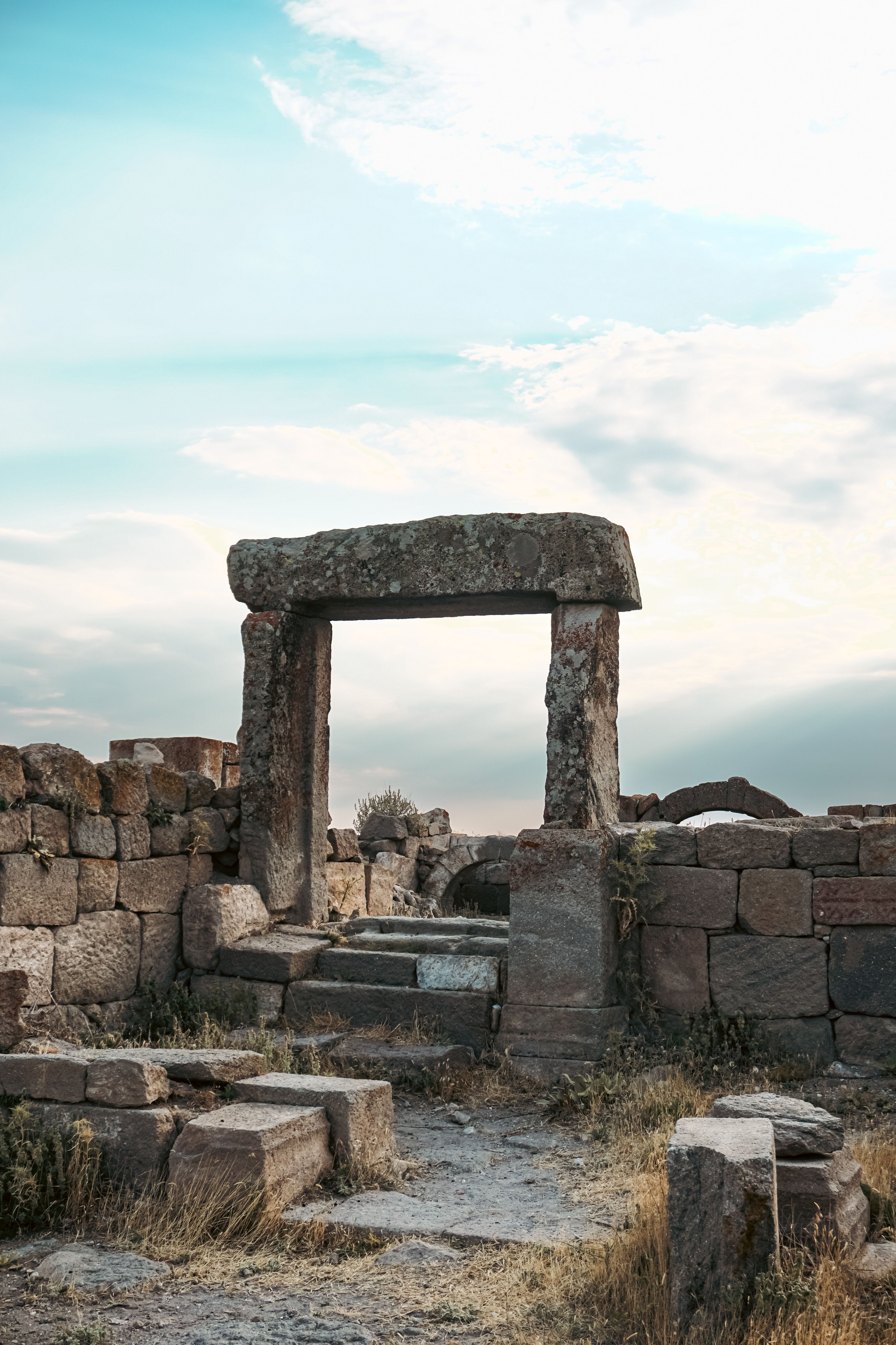 The ruins of a stone structure in the middle of a field · Free Stock Photo
