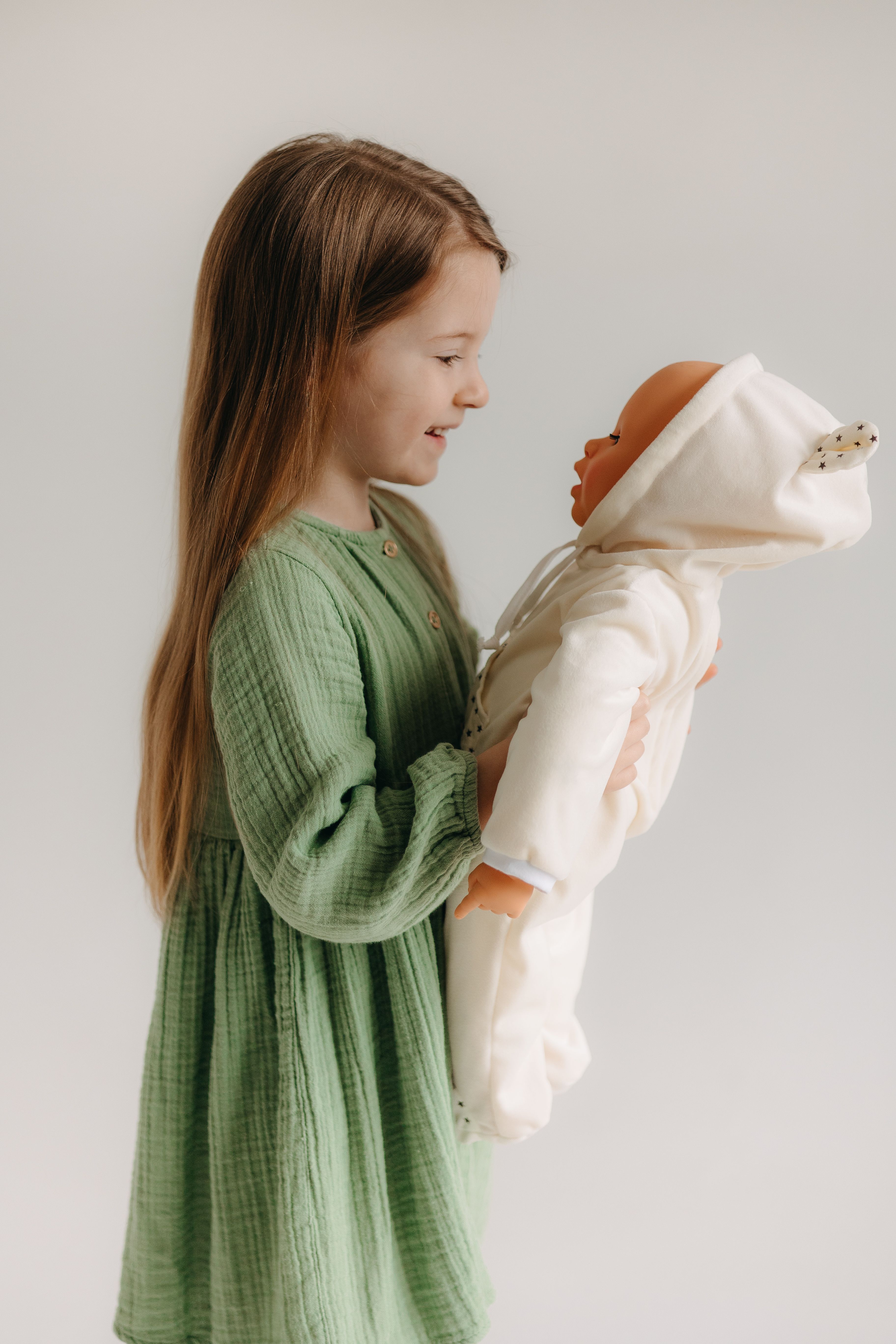 A young girl holding a doll in her hands · Free Stock Photo