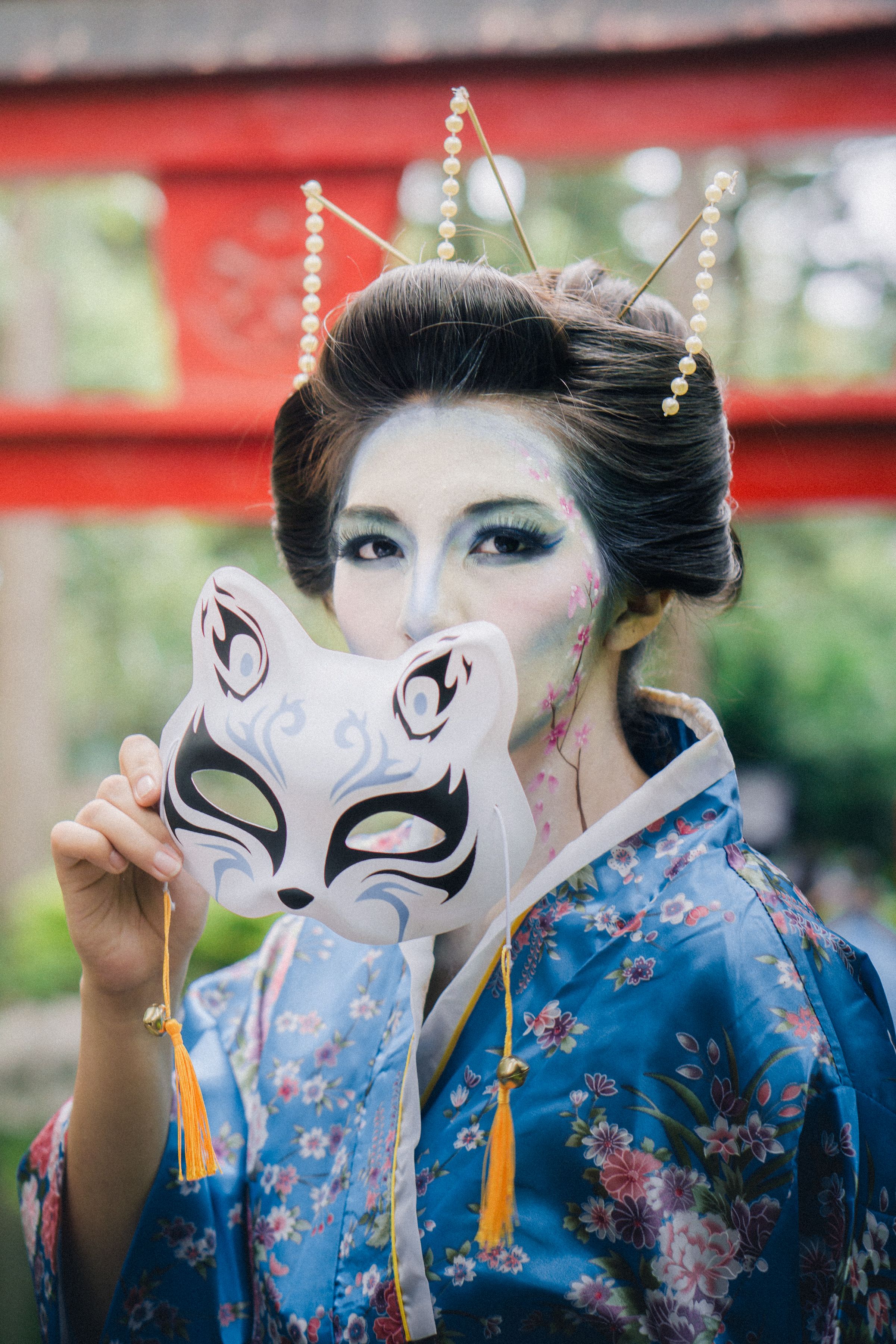 A woman in a geisha costume holding a mask · Free Stock Photo