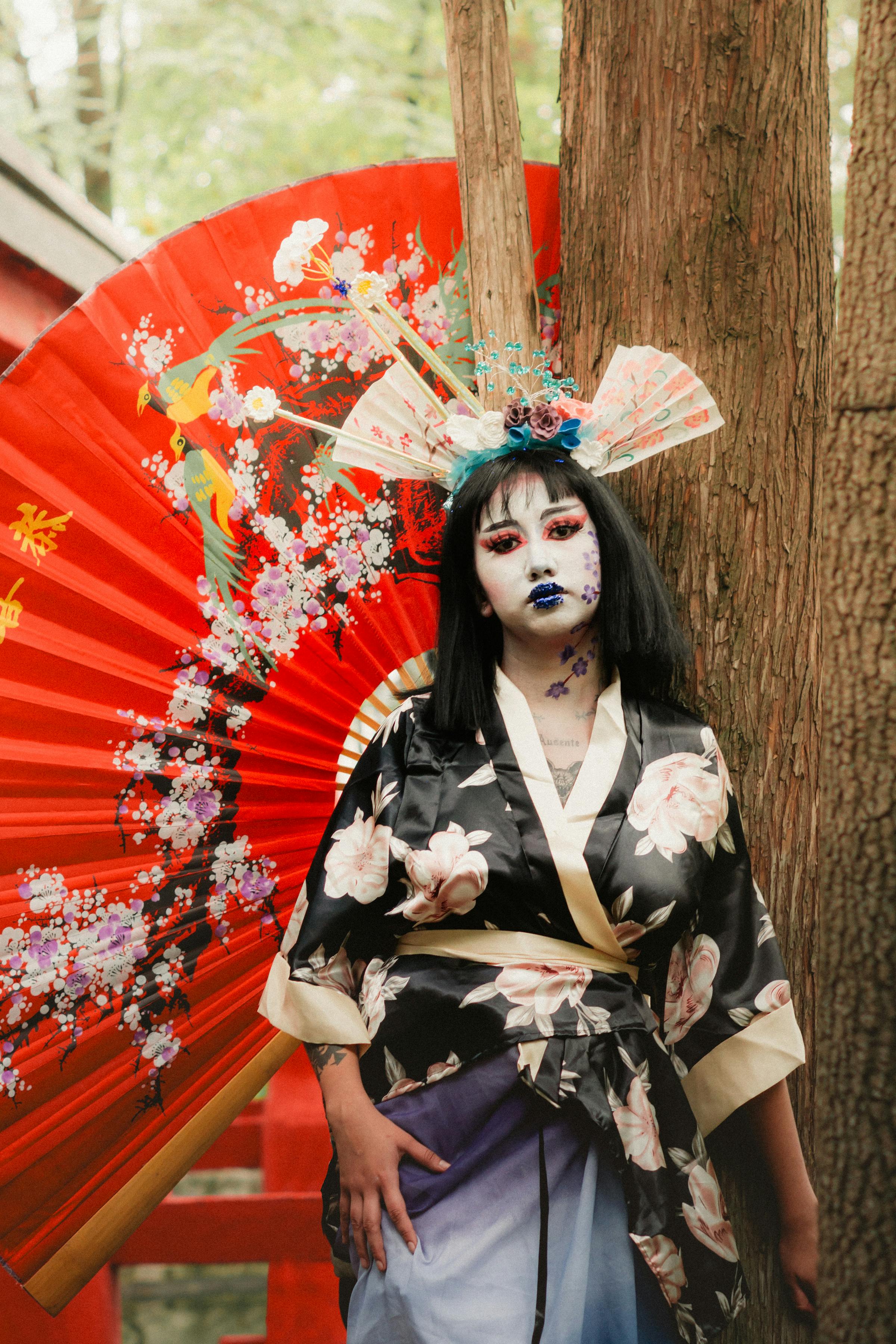 A woman in a geisha costume with a red umbrella · Free Stock Photo