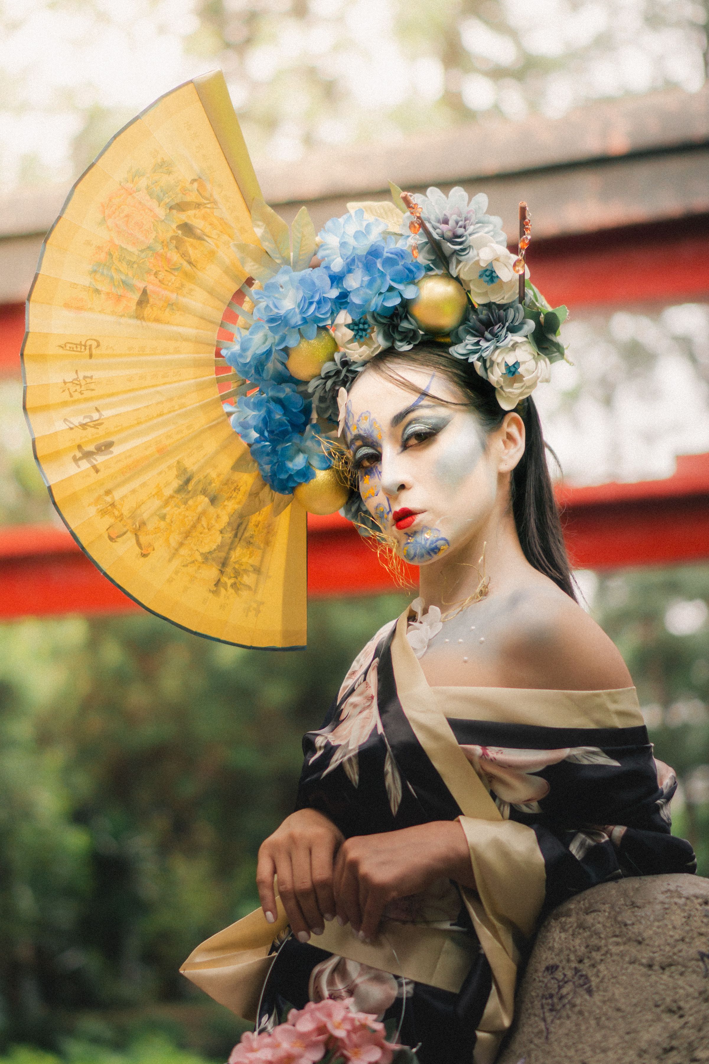 A woman in a geisha costume with a yellow fan · Free Stock Photo
