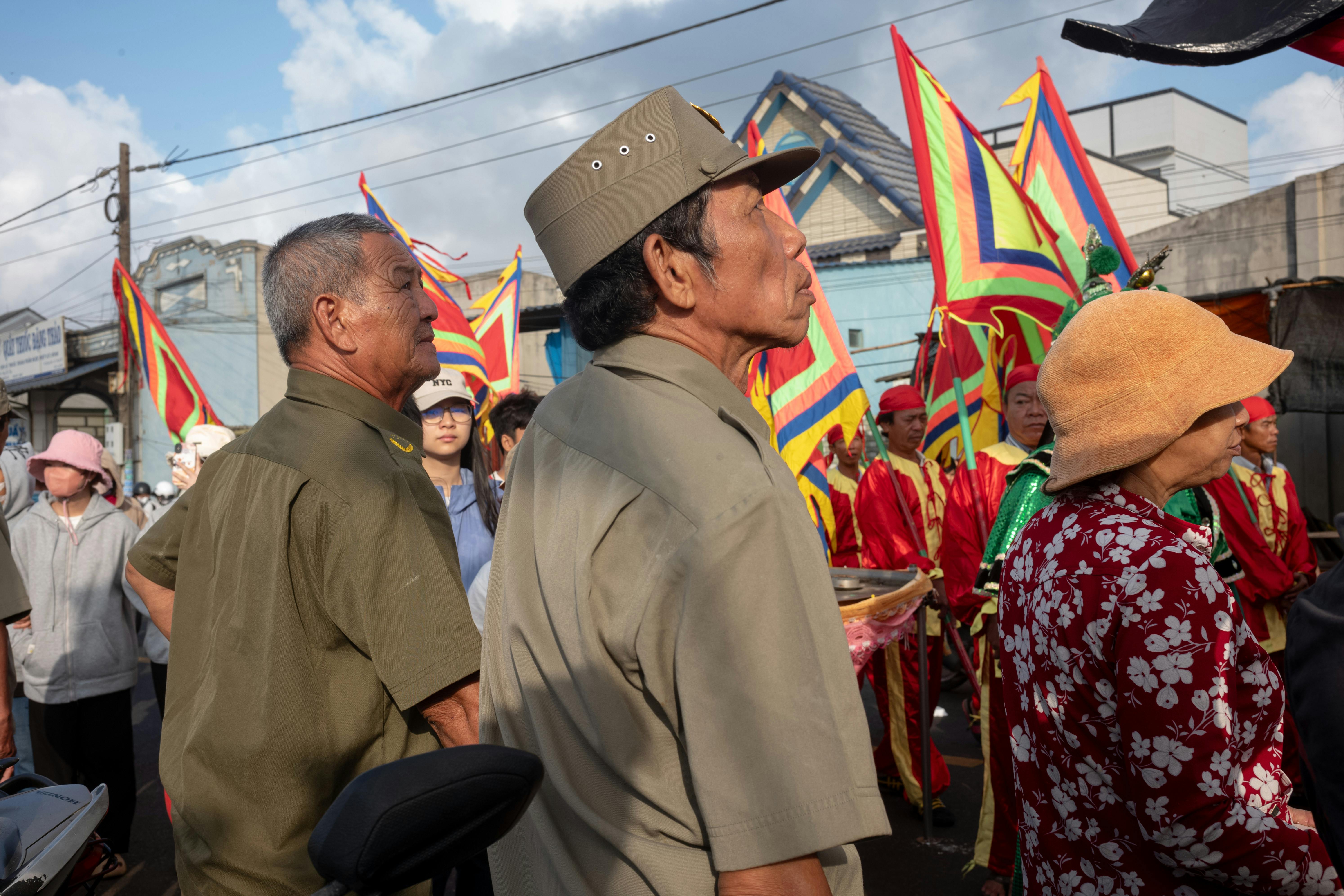 A group of people standing in a parade with flags · Free Stock Photo