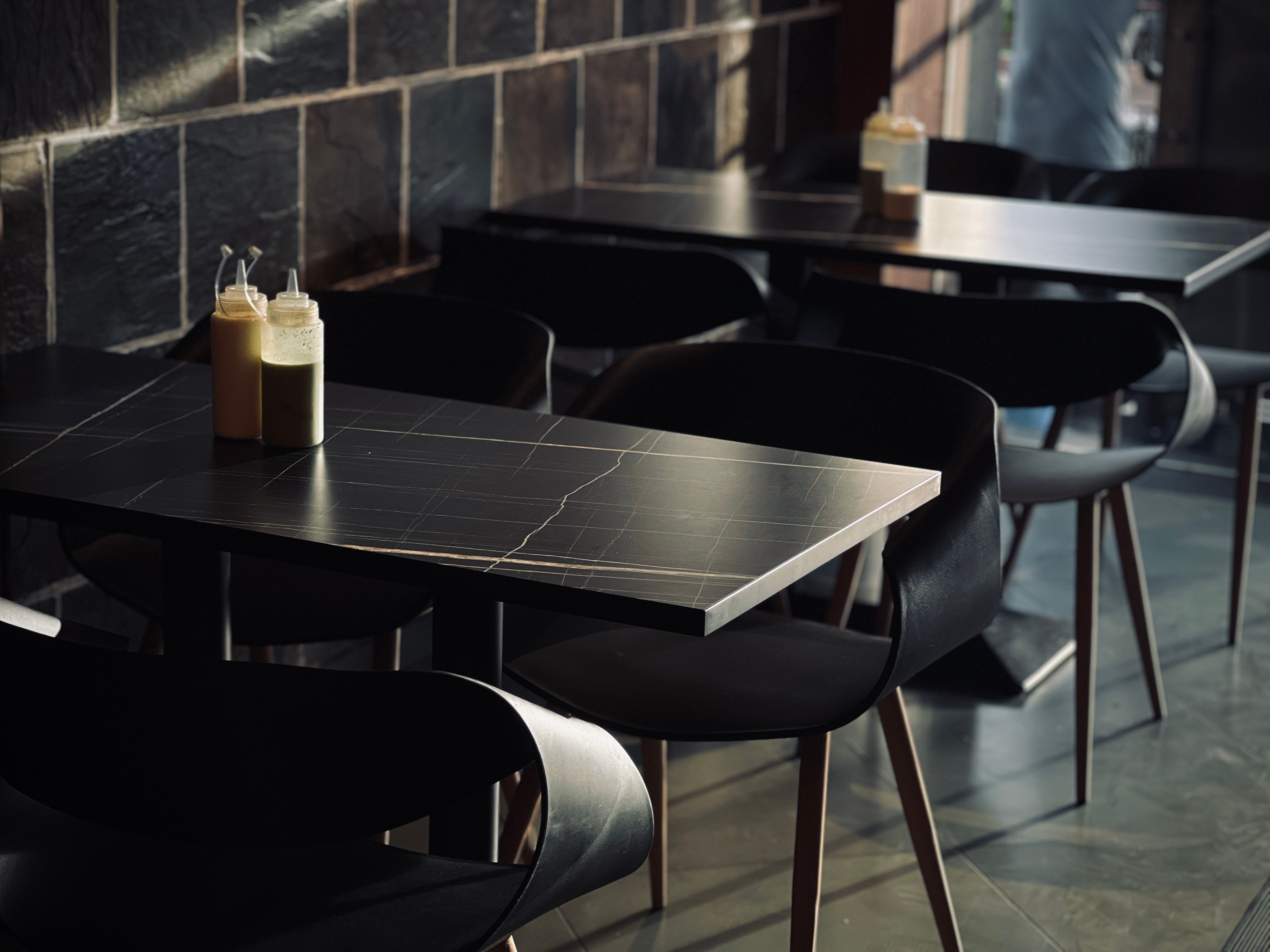 Black tables and chairs in a restaurant · Free Stock Photo