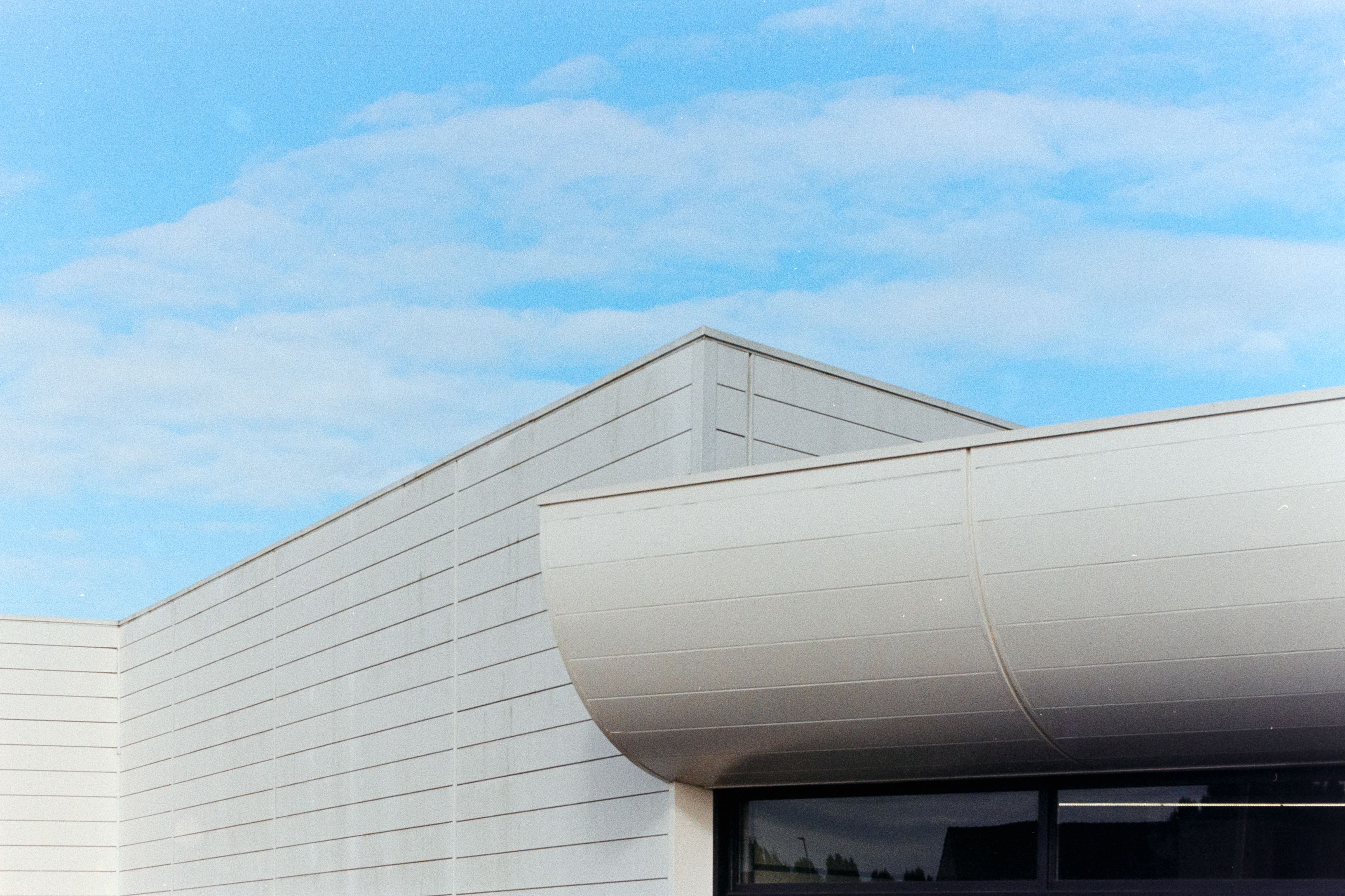 A building with a white roof and a blue sky · Free Stock Photo