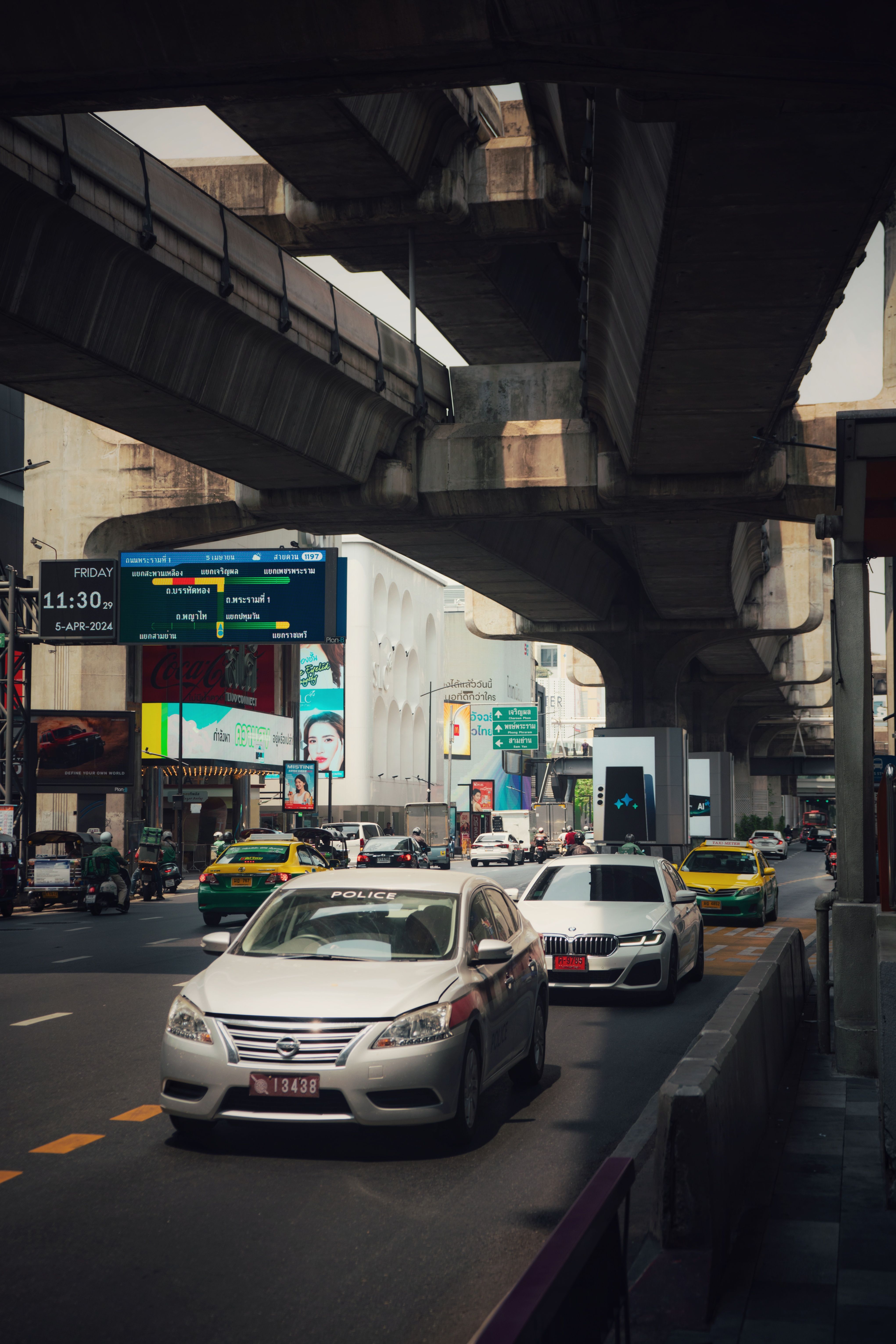 A city street with cars driving under a bridge · Free Stock Photo