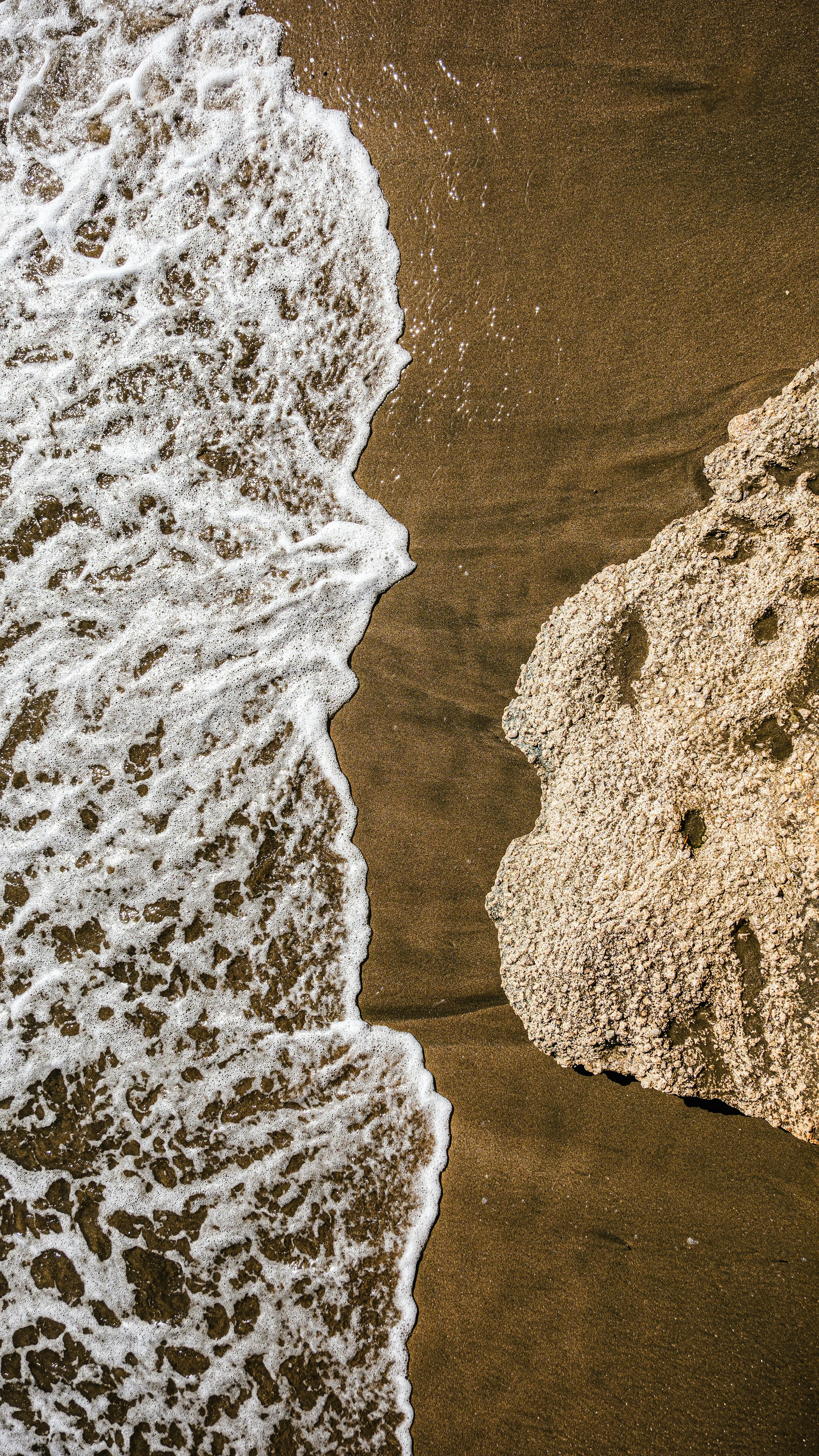A close up of a sand and water surface · Free Stock Photo