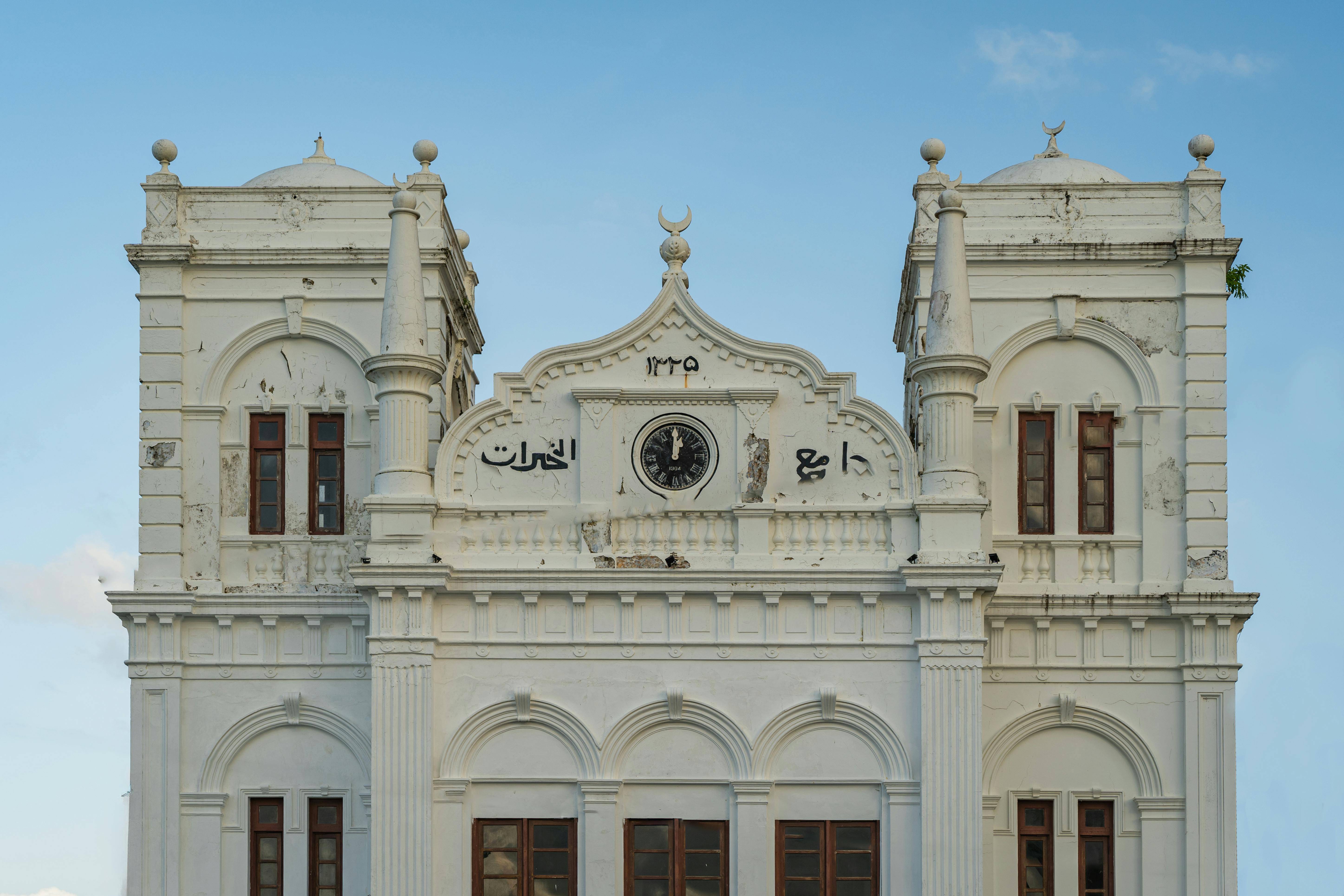 A large white building with a clock on top · Free Stock Photo
