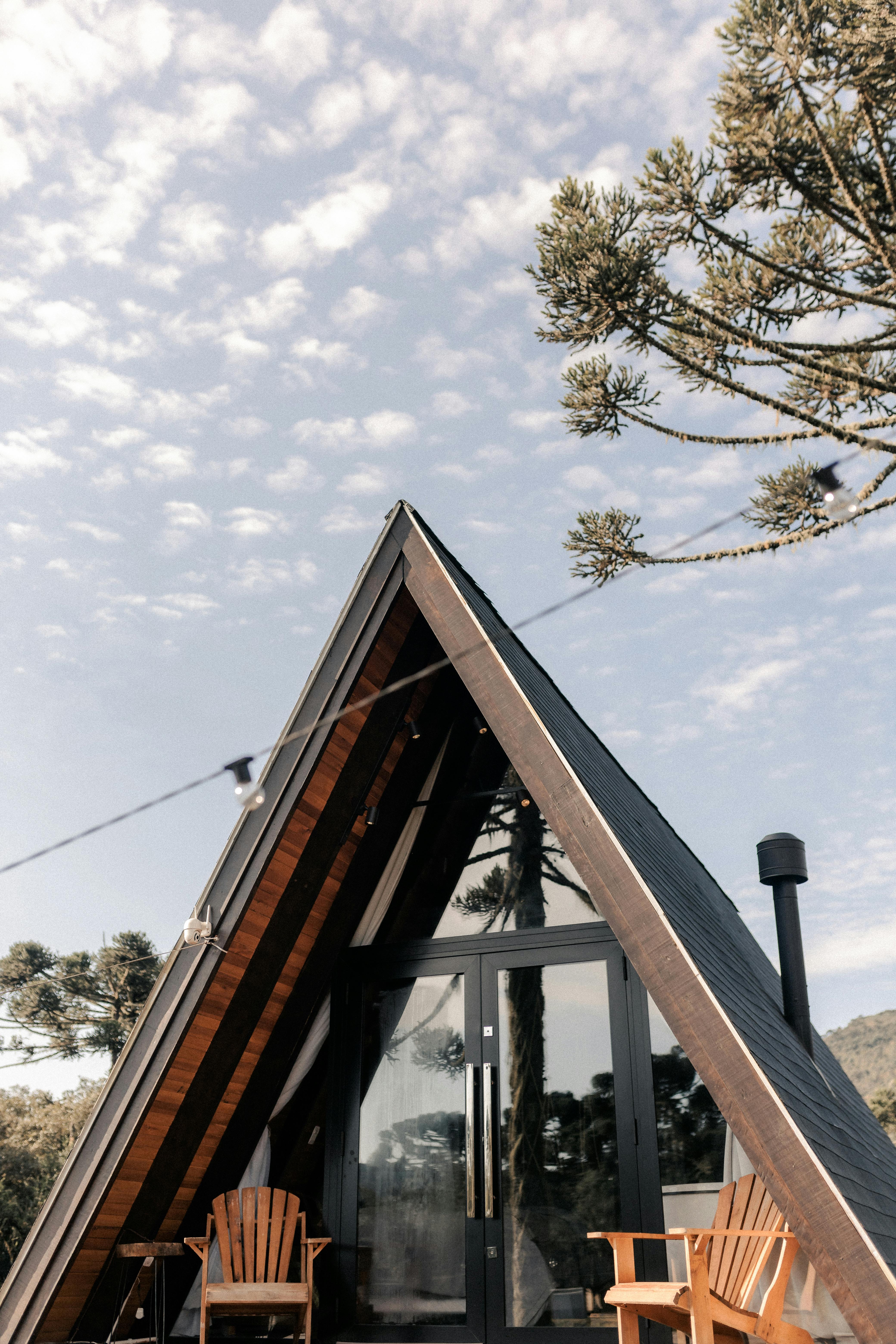 A triangle shaped cabin with two chairs and a table · Free Stock Photo