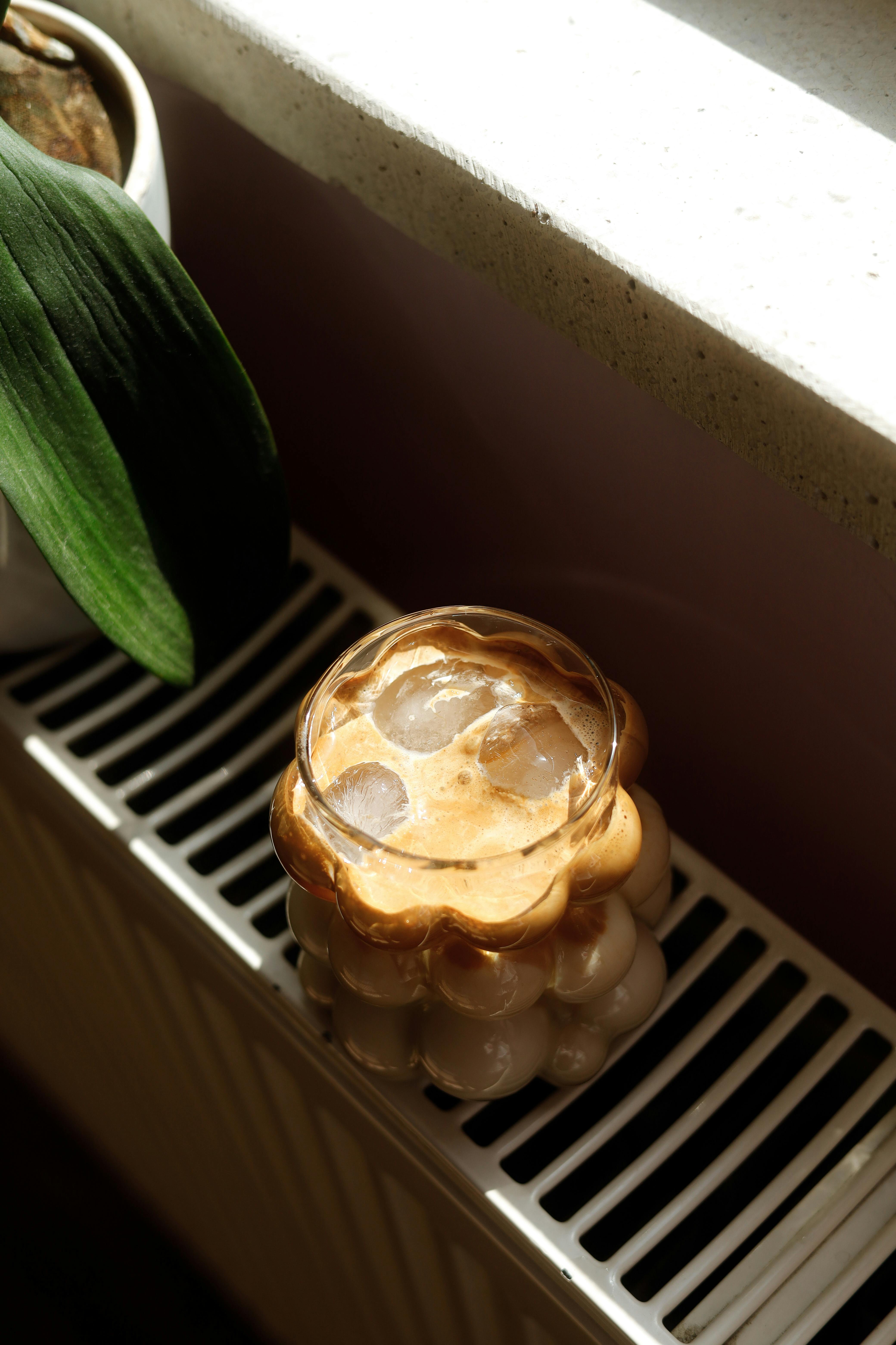 A glass of coffee sitting on a radiator · Free Stock Photo