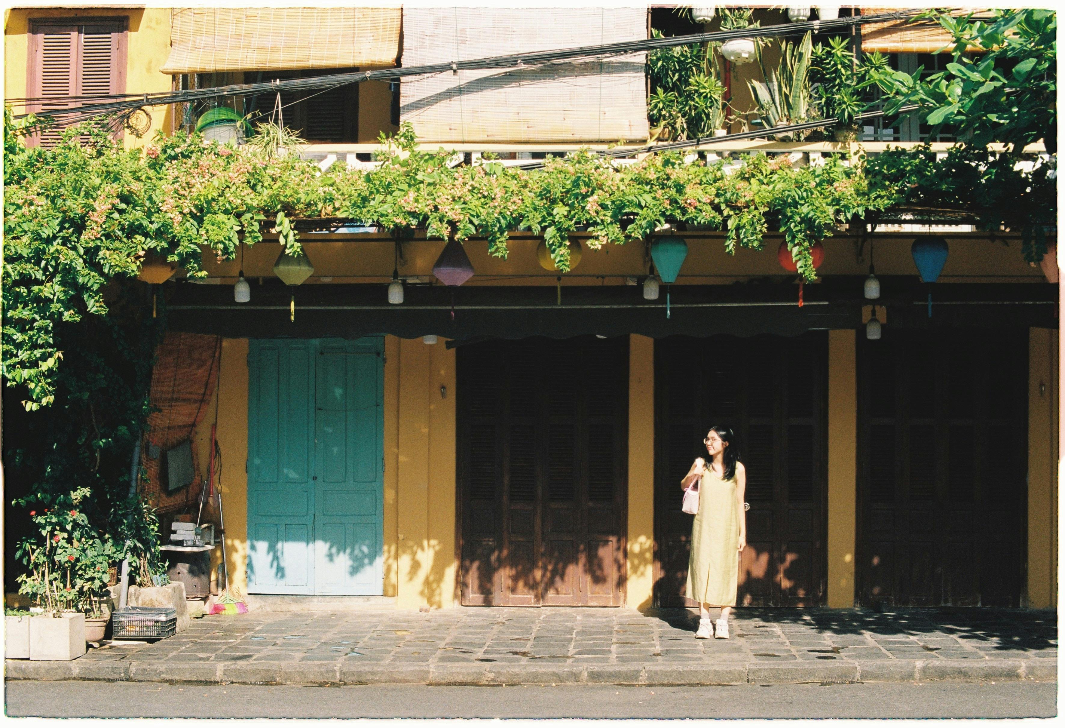 A woman standing outside of a building with a yellow door · Free Stock ...