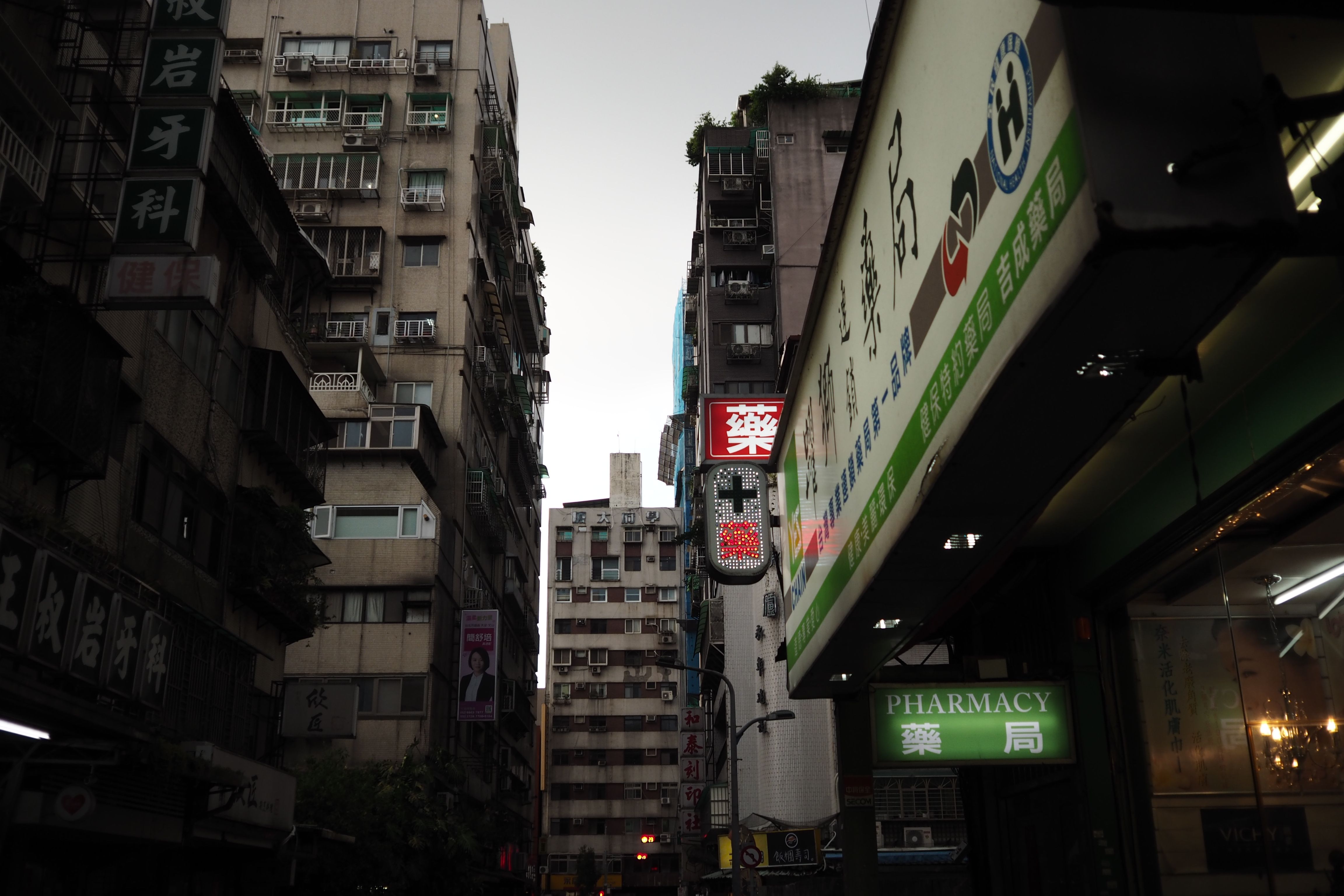 A street with many buildings and signs in the background · Free Stock Photo
