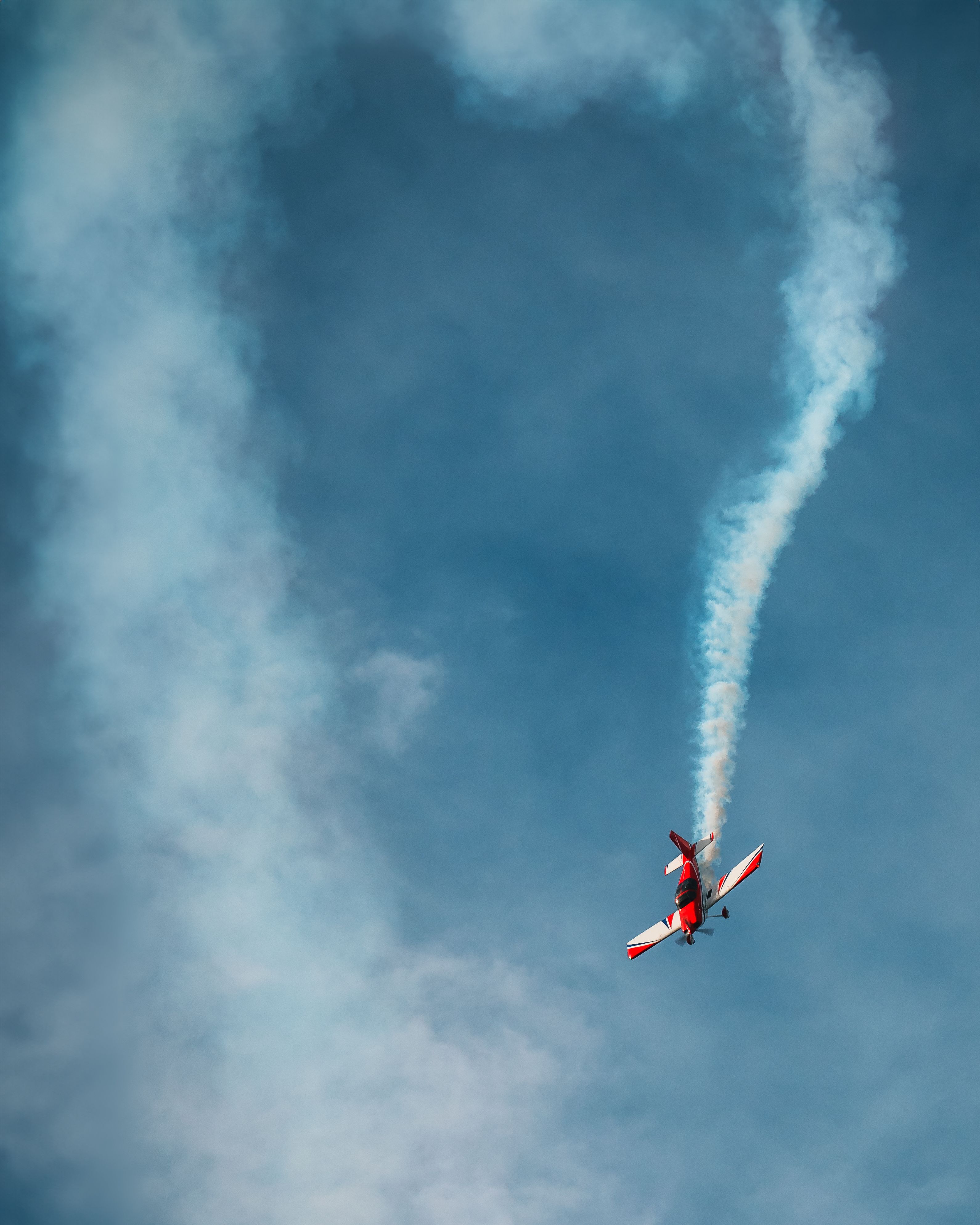 A small plane flying through the air with smoke coming out of it · Free ...