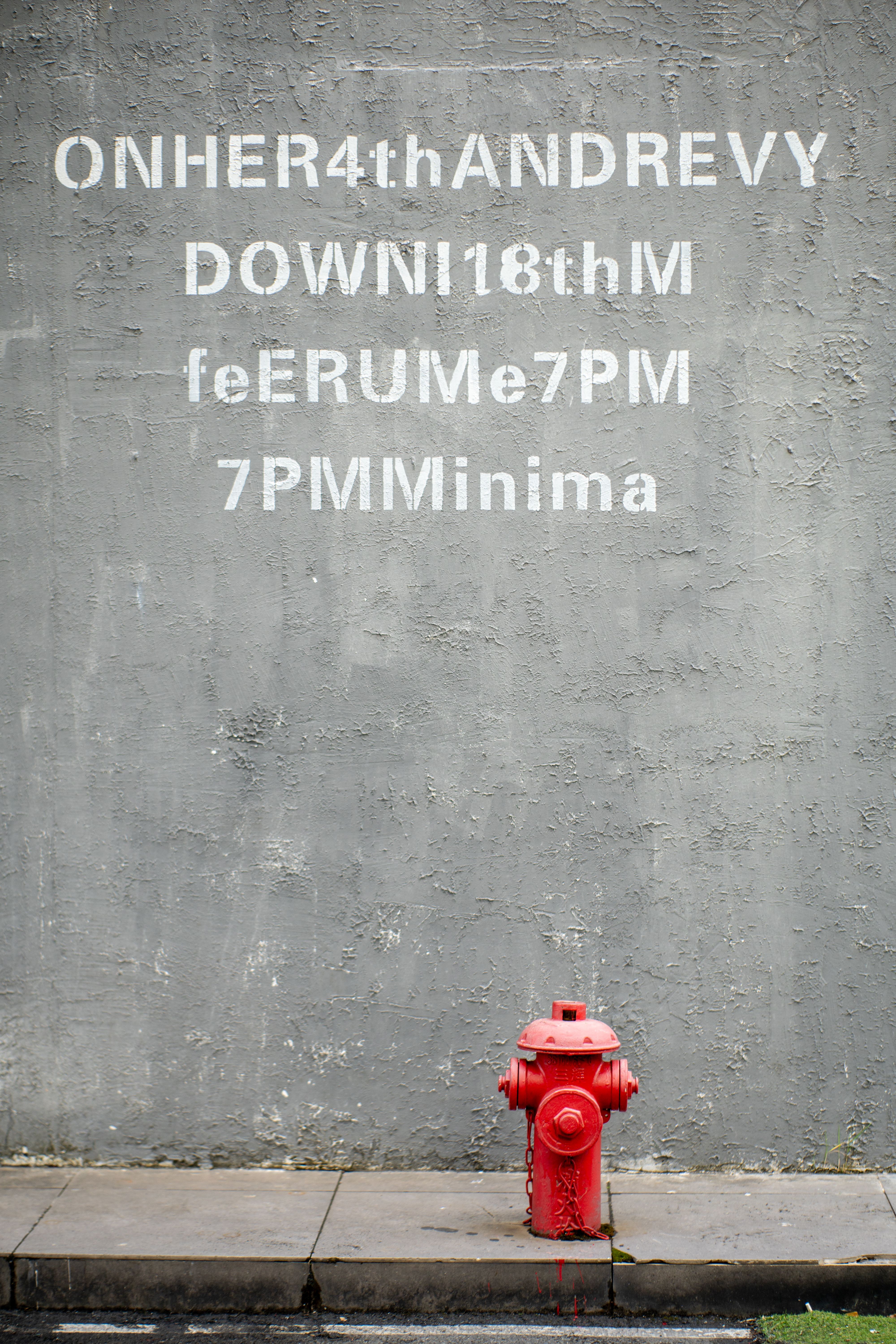 A red fire hydrant with the words on the wall · Free Stock Photo
