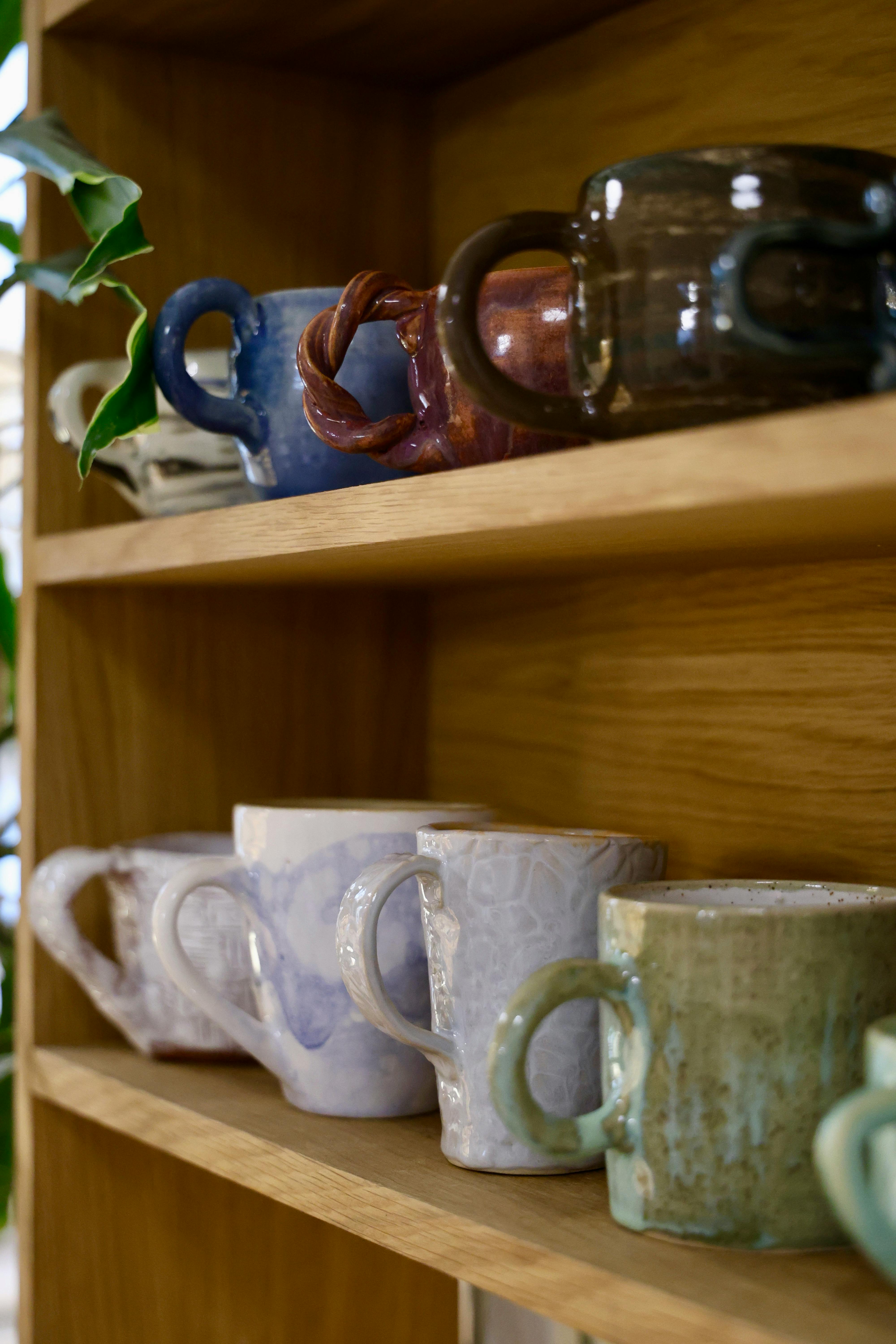 A shelf with many different types of mugs on it · Free Stock Photo