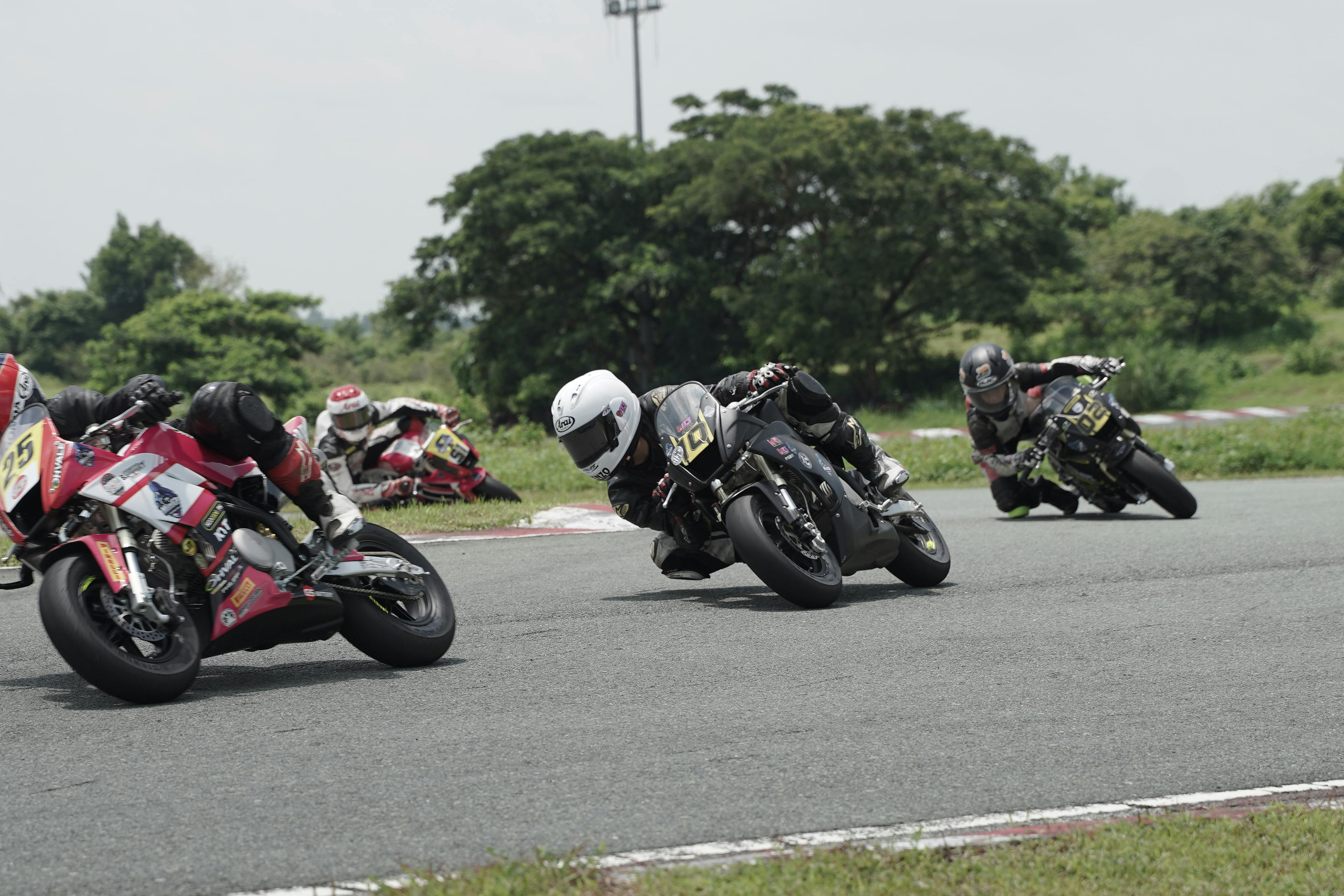 Three motorcyclists are racing on a track · Free Stock Photo