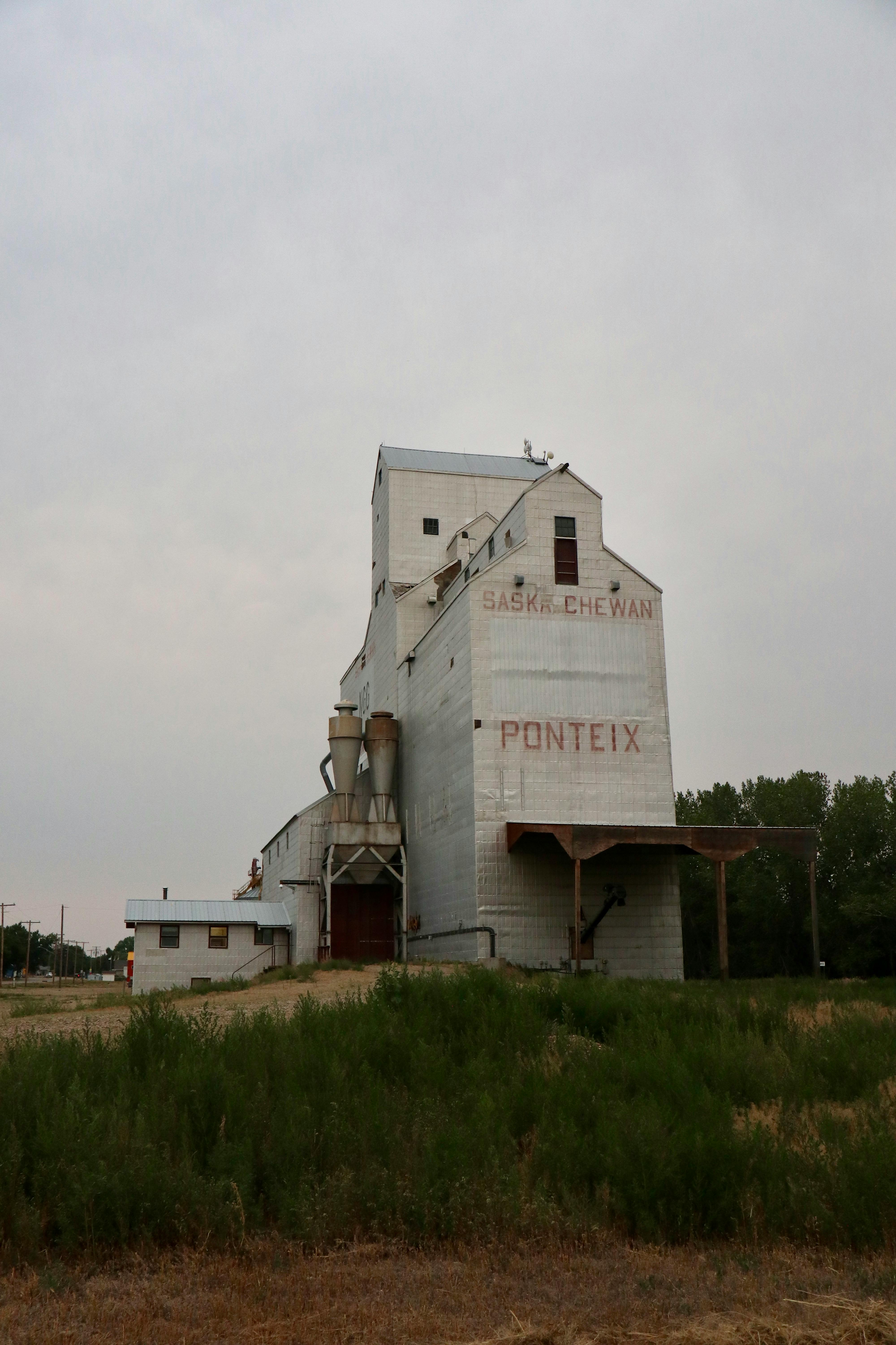 A grain elevator in the middle of a field · Free Stock Photo