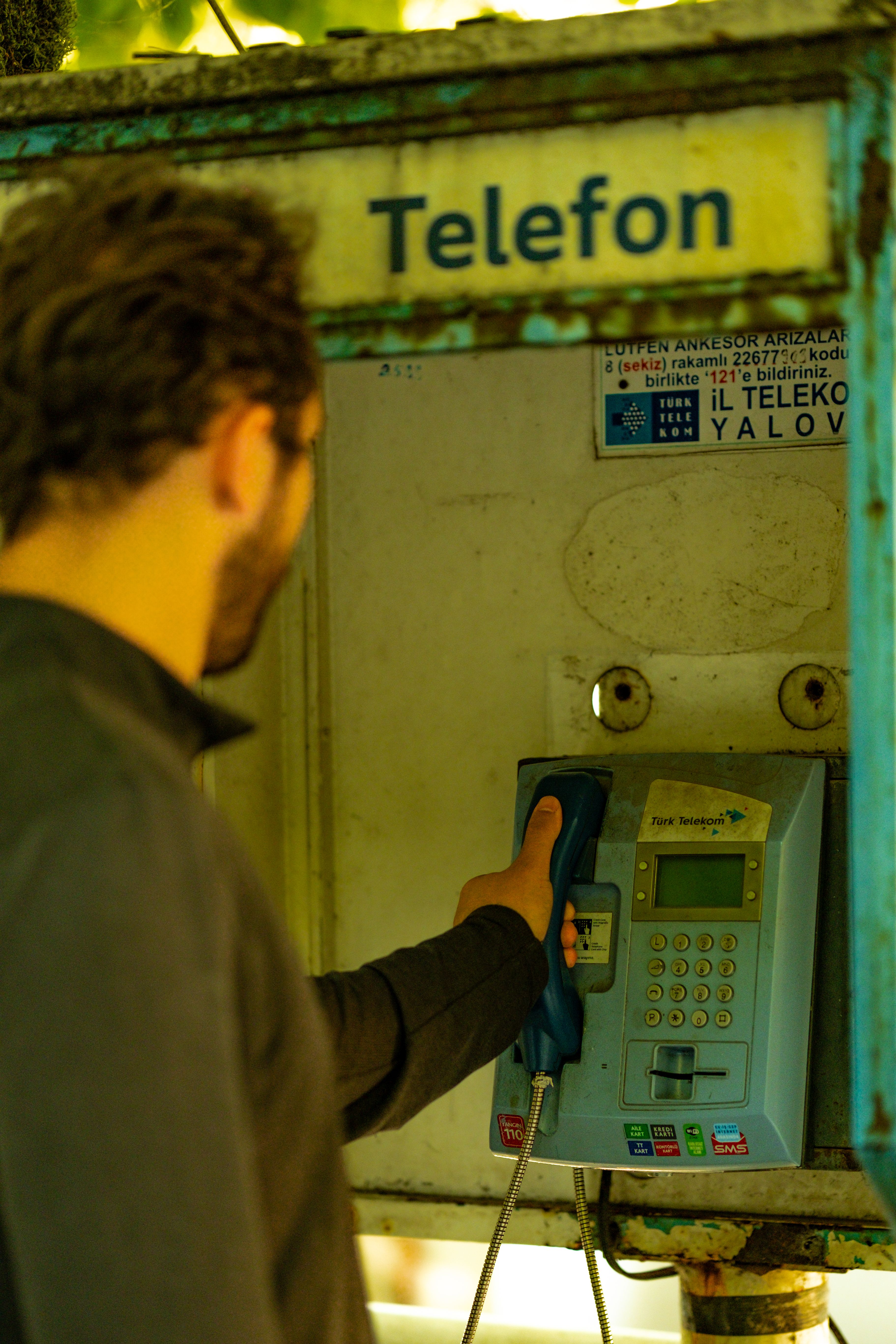 A man is using a pay phone to call someone · Free Stock Photo
