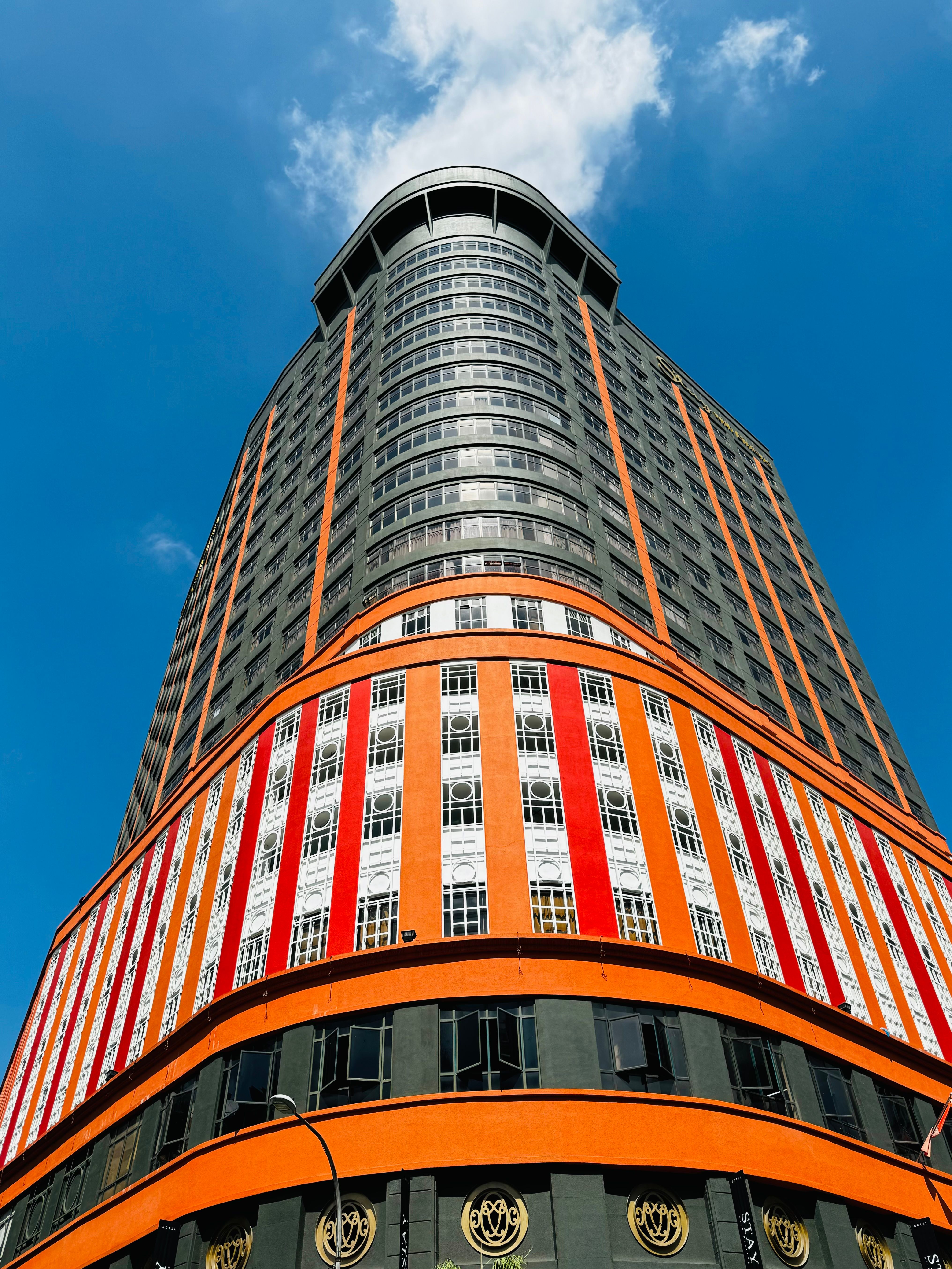 A tall building with a red and orange stripe · Free Stock Photo