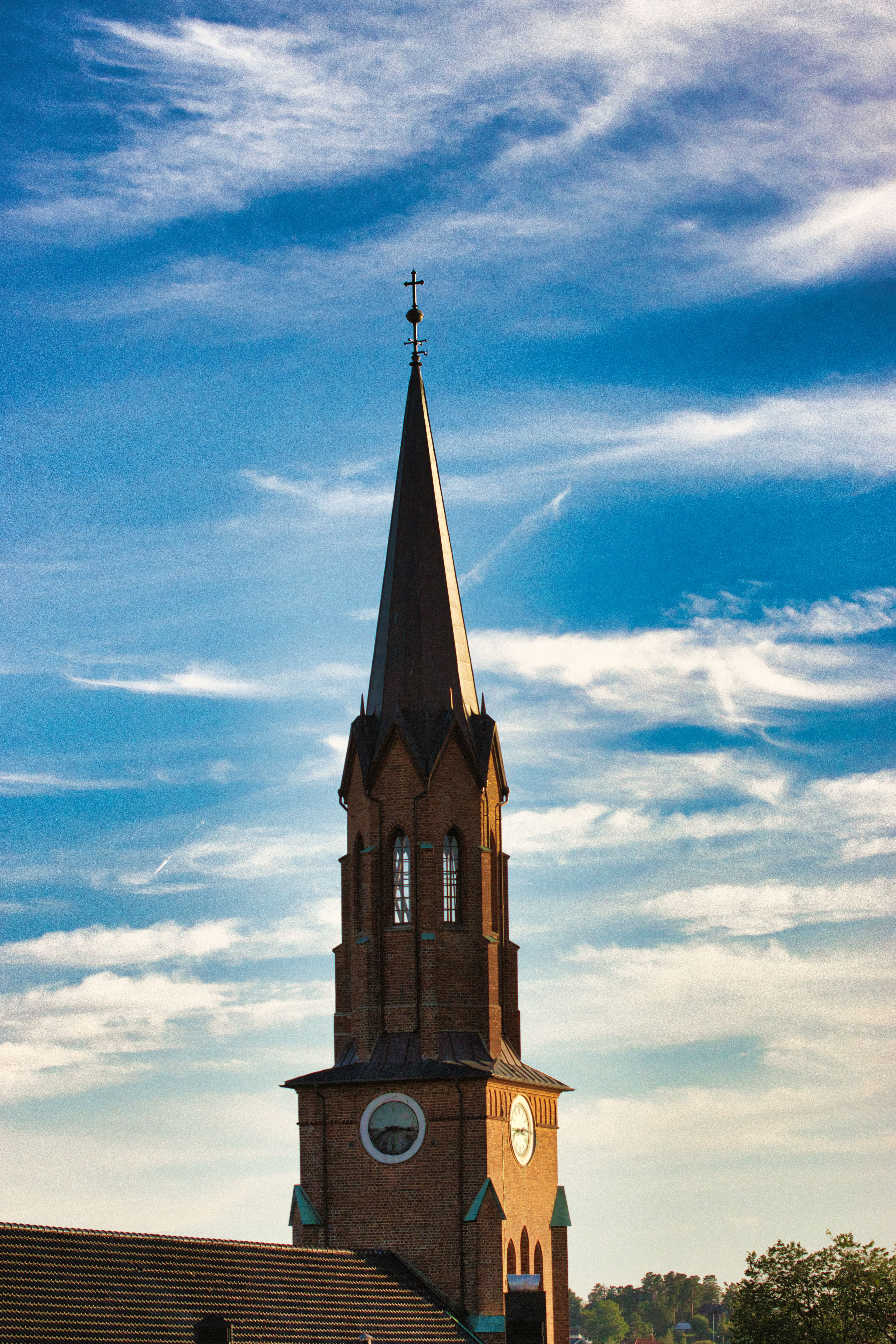 A church steeple with a clock tower in the background · Free Stock Photo