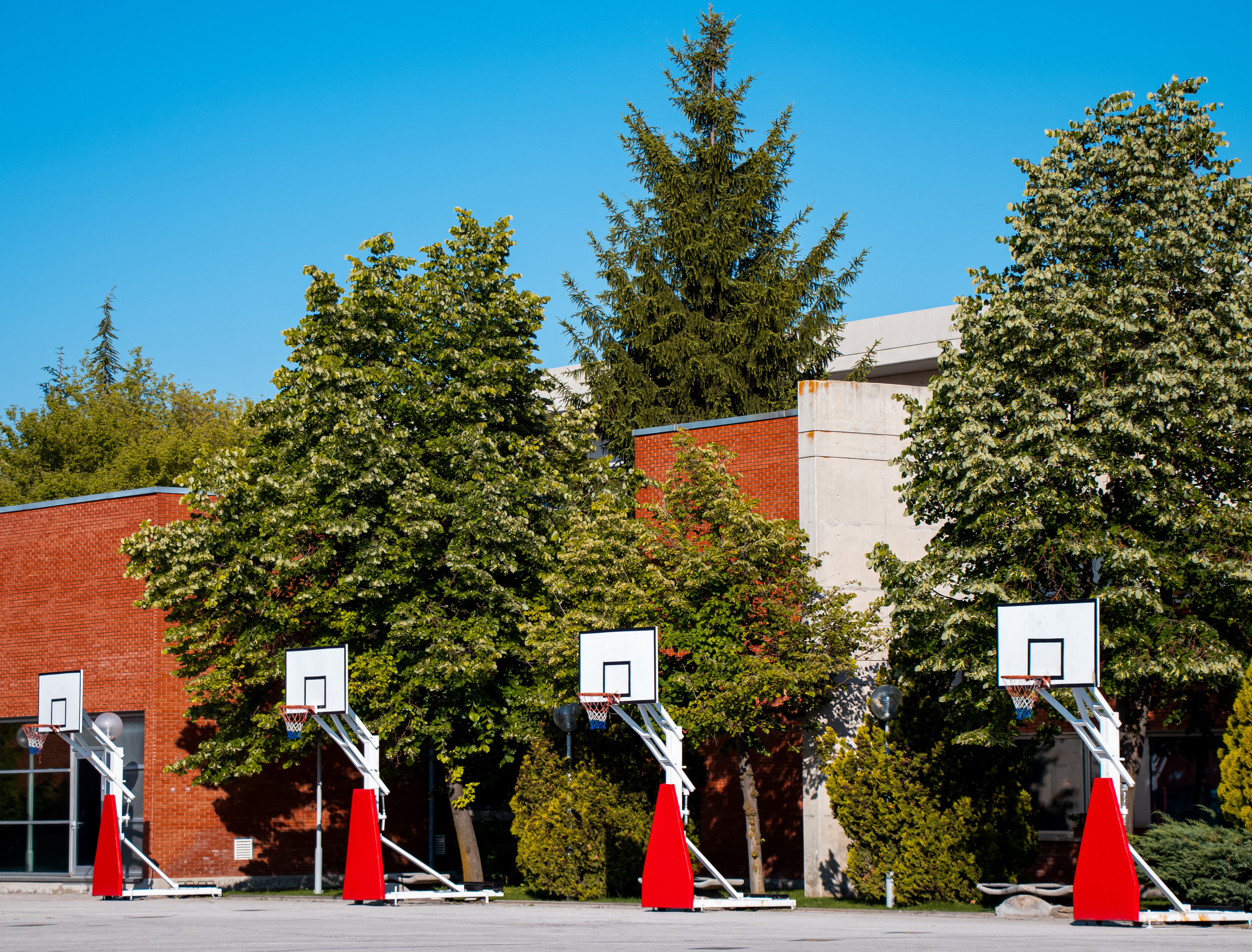 A row of basketball hoops in front of a building · Free Stock Photo